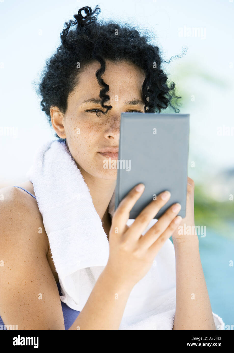 Woman looking in hand mirror Stock Photo - Alamy