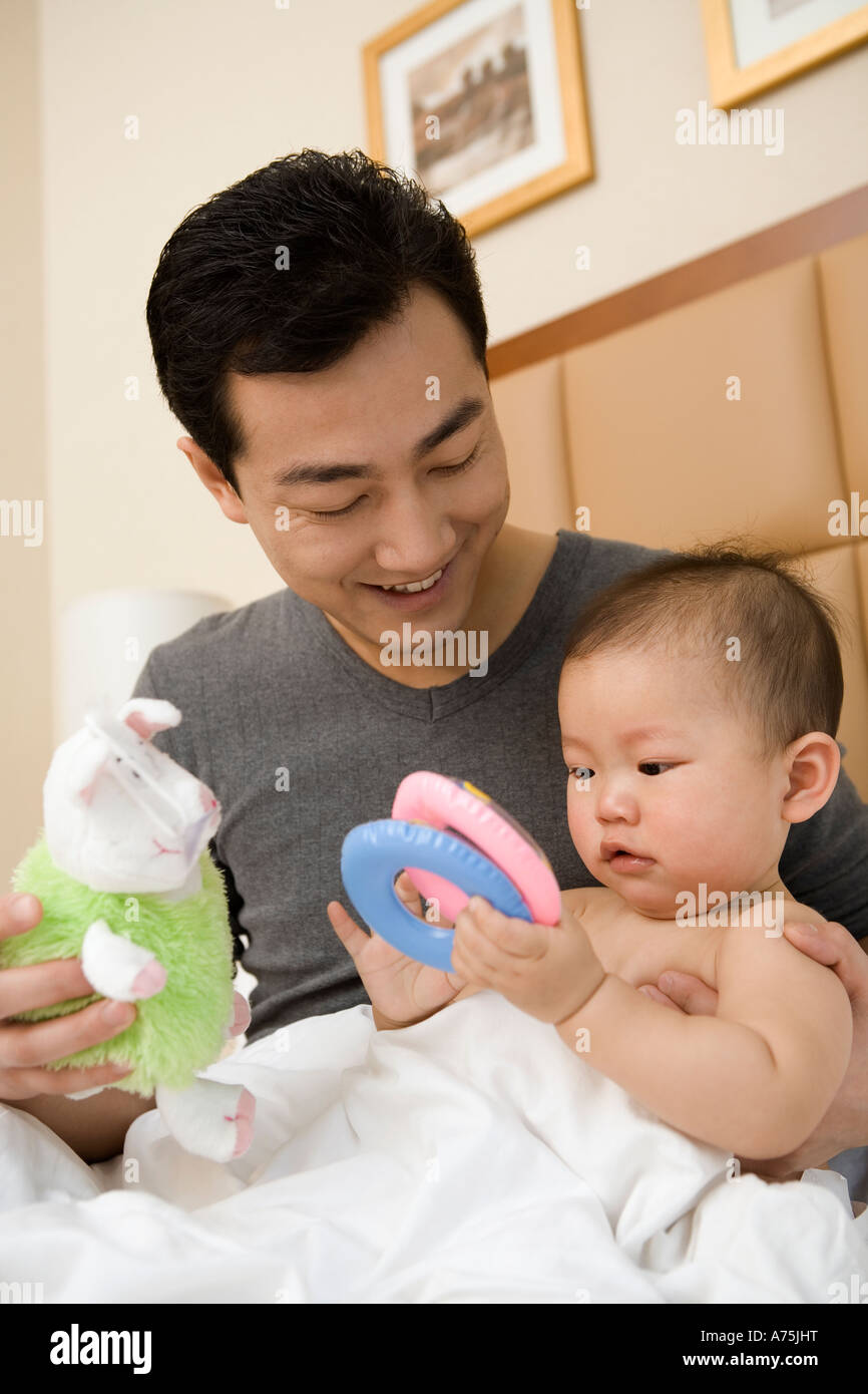Man playing with his baby in bed Stock Photo - Alamy