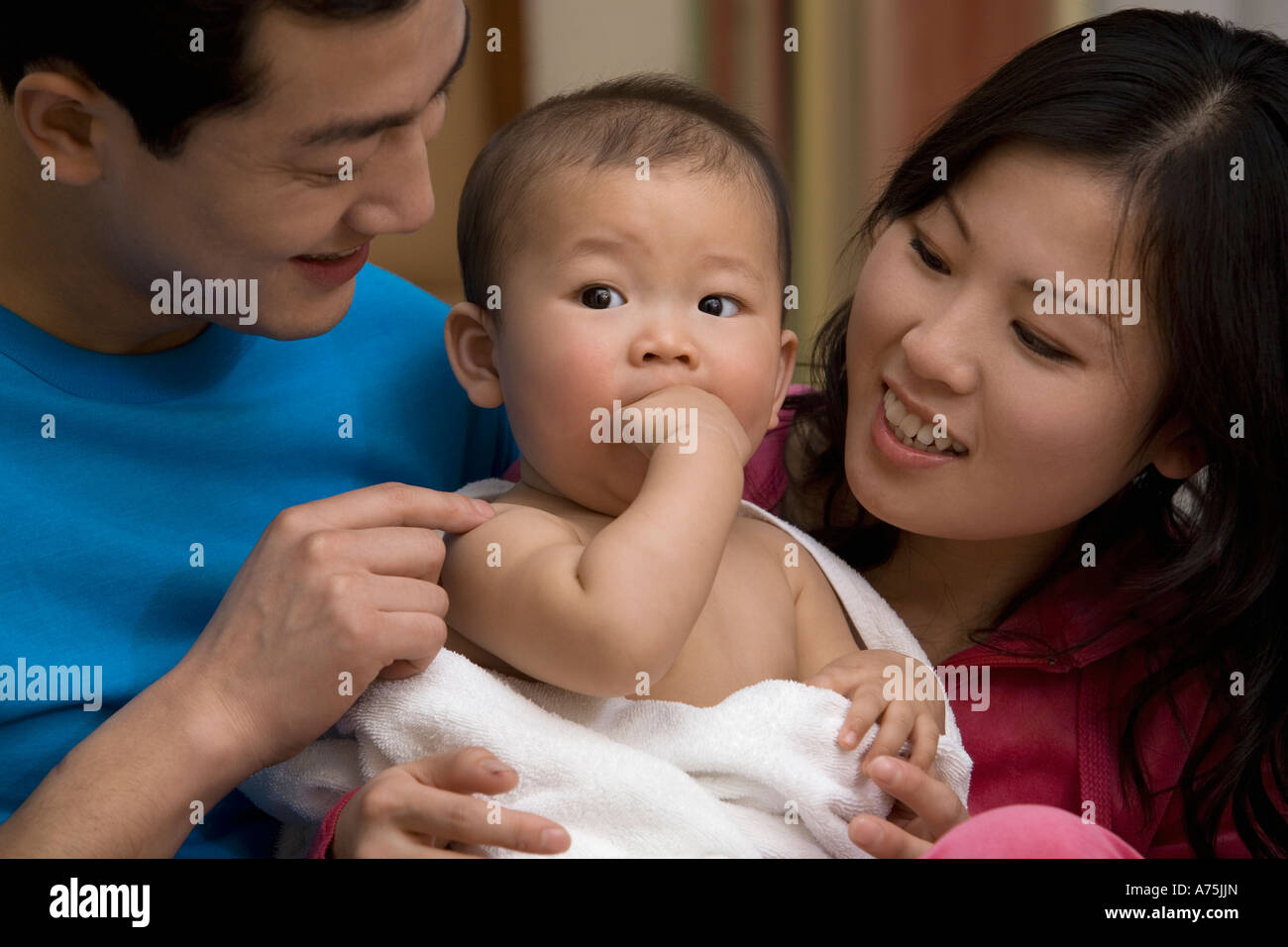 Couple admiring their baby Stock Photo - Alamy