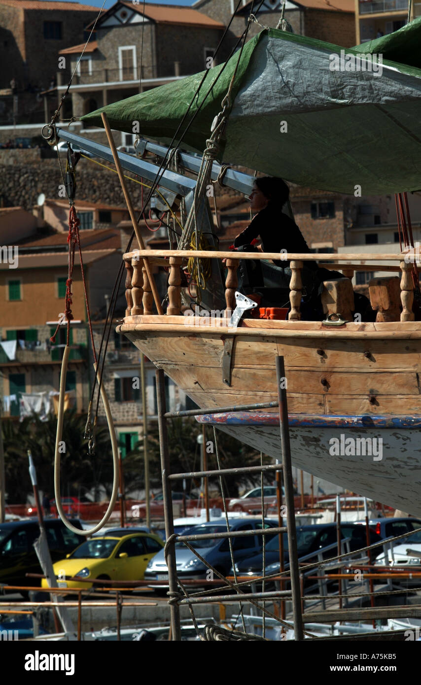 woman rests whilst laking repairs to a boat in dry dock soller majorca ...