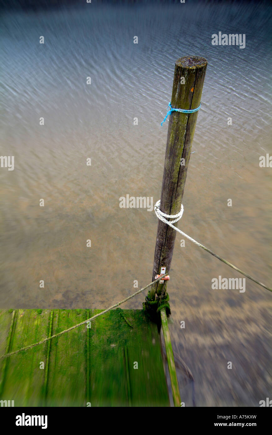 post beside water with ropes Stock Photo - Alamy