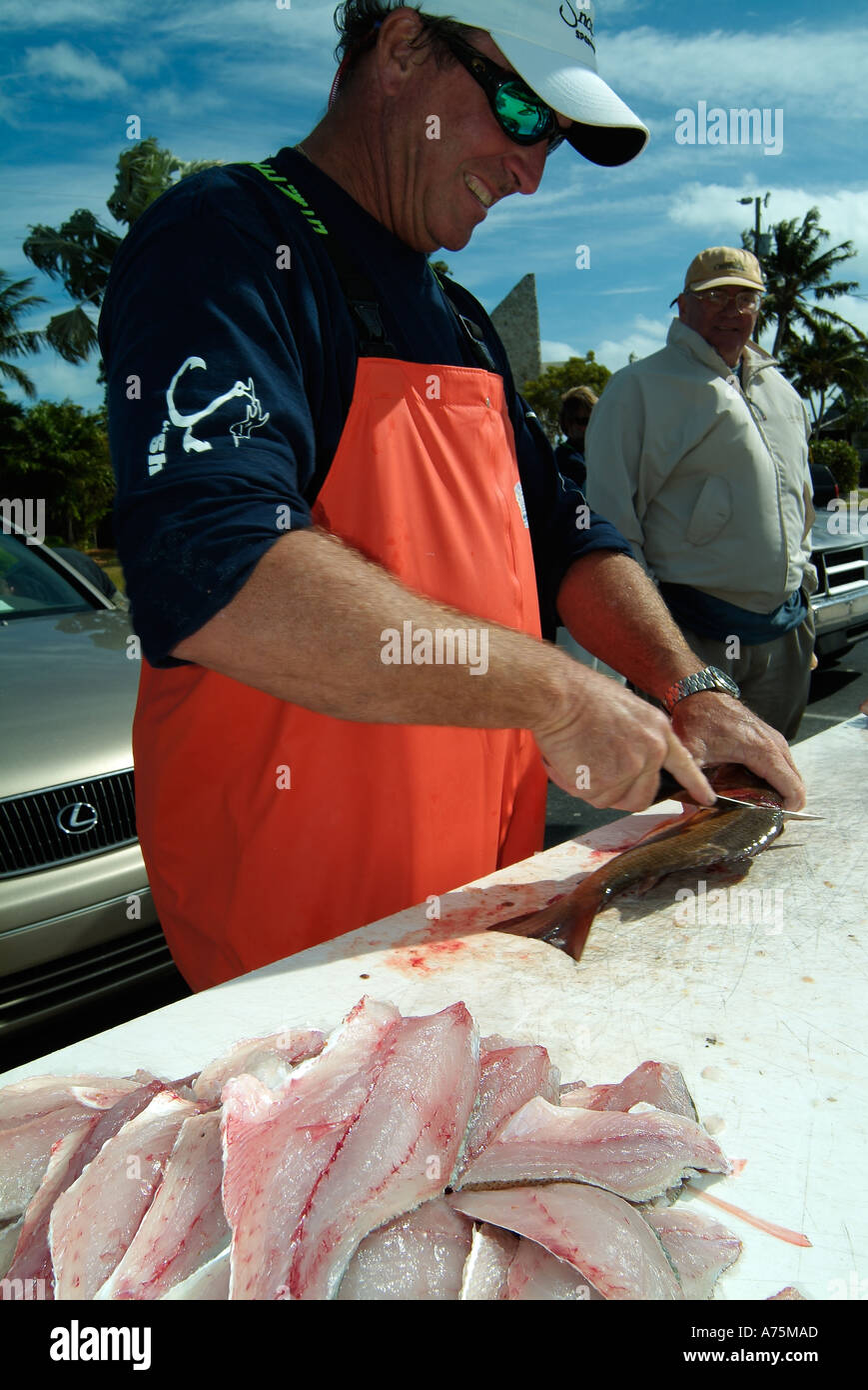 Fisherman cleaning and cutting fish Stock Photo - Alamy