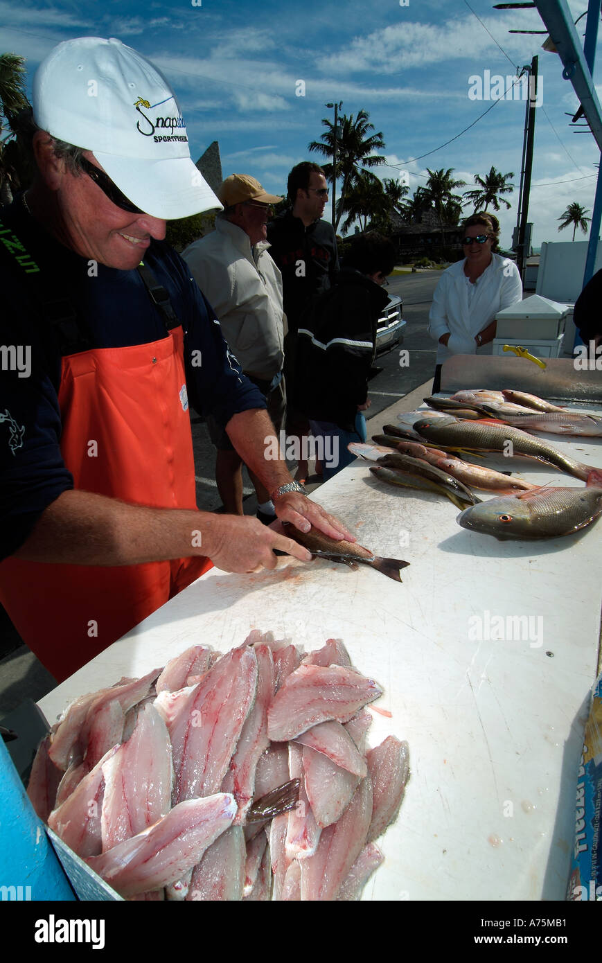 Fisherman cleaning and cutting fish Stock Photo - Alamy