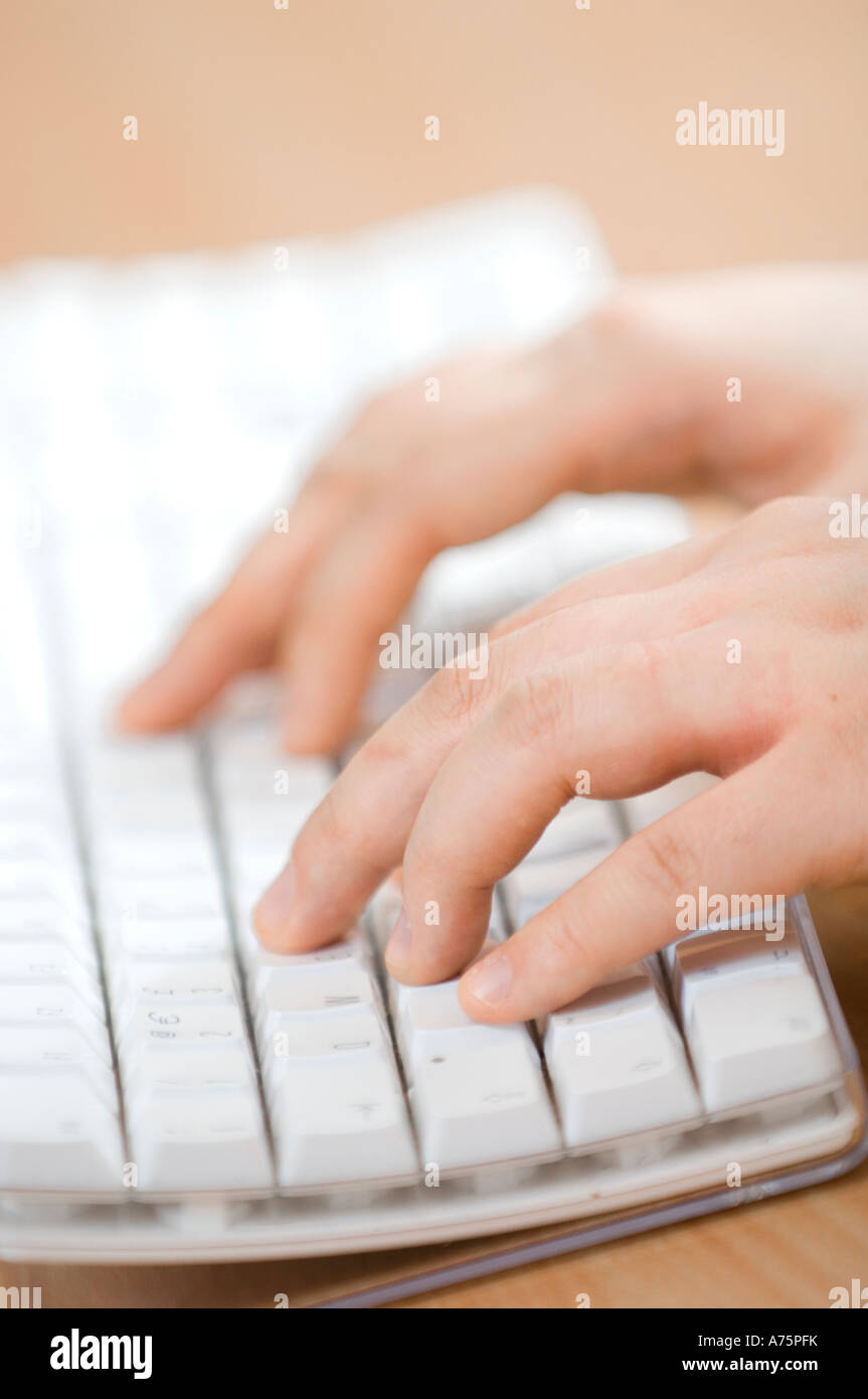 Close up picture of a white womans hands typing on a white keyboard ...