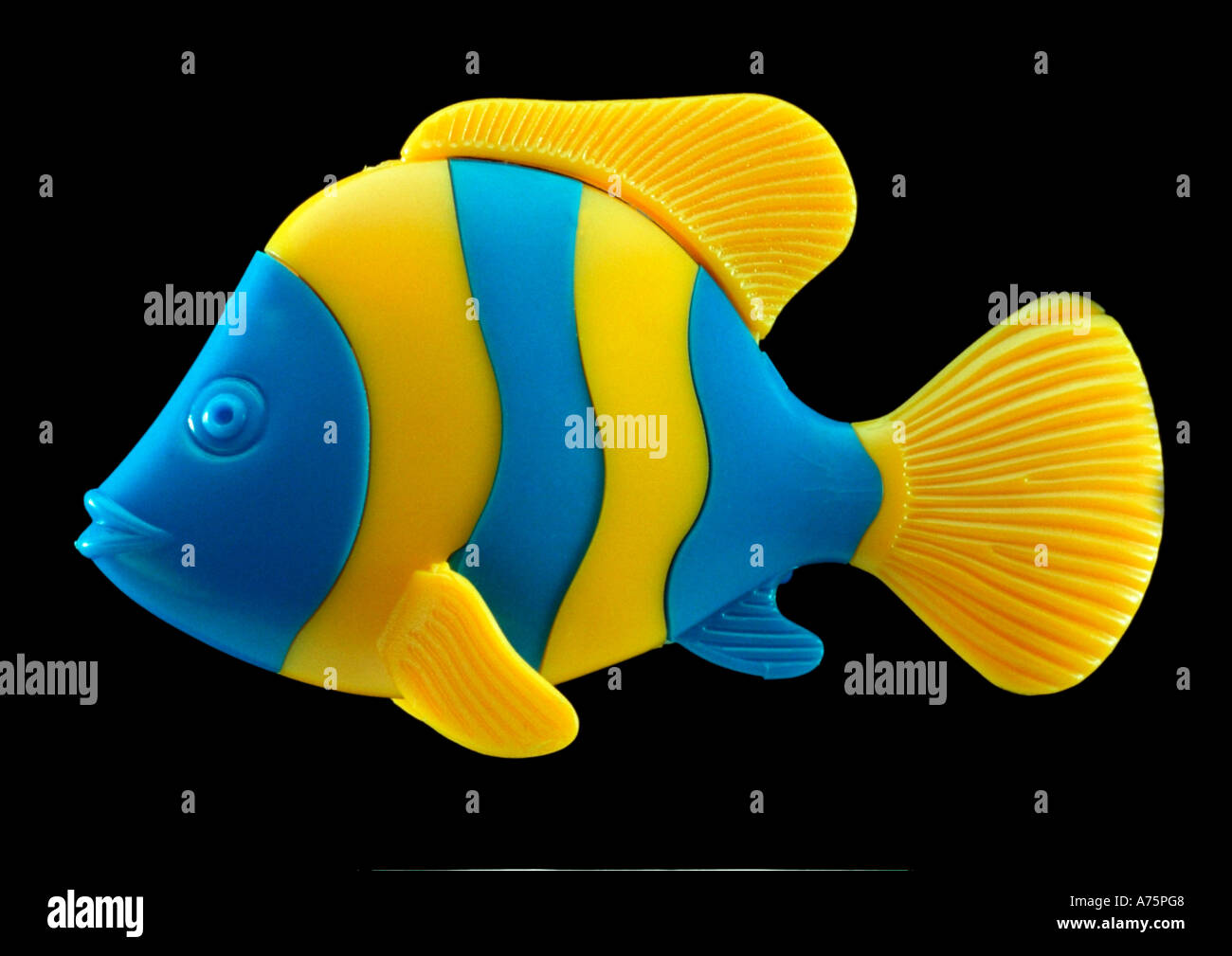 Blue and yellow plastic toy fish on black background Stock Photo - Alamy