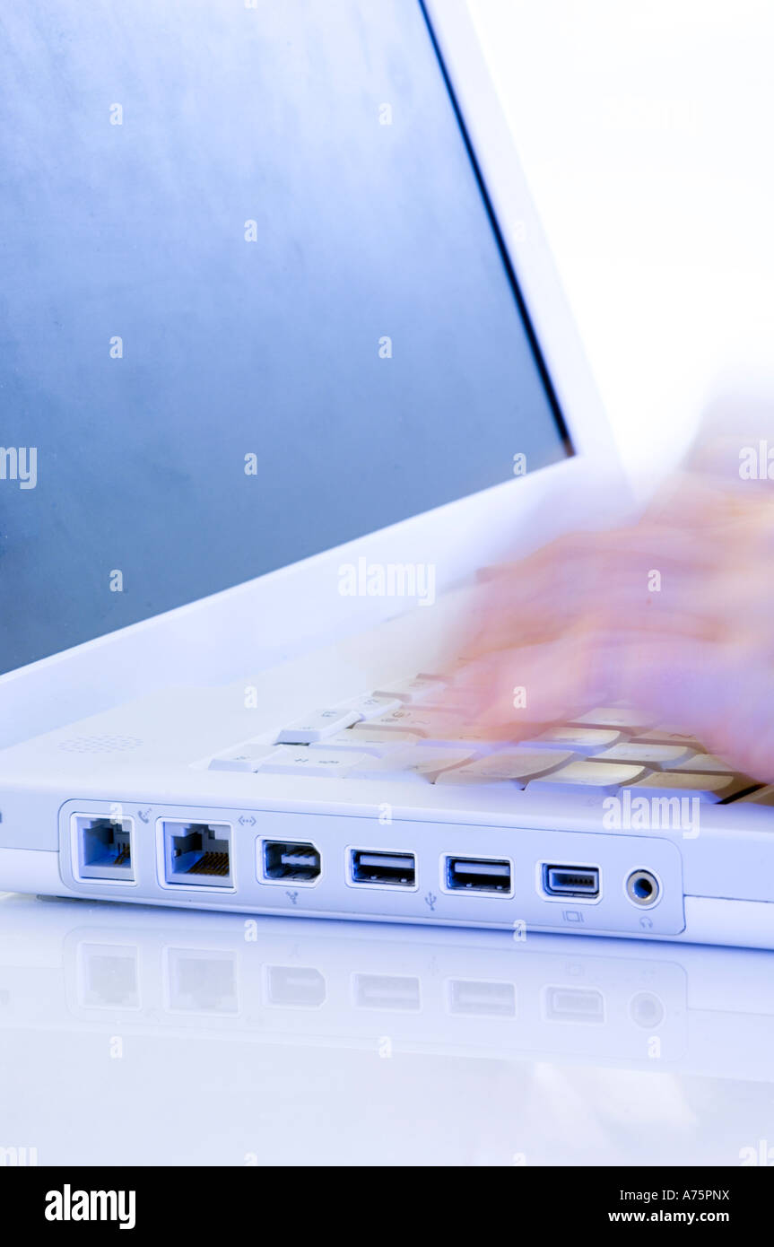 Hands typing at speed on laptop computer keyboard against white ...