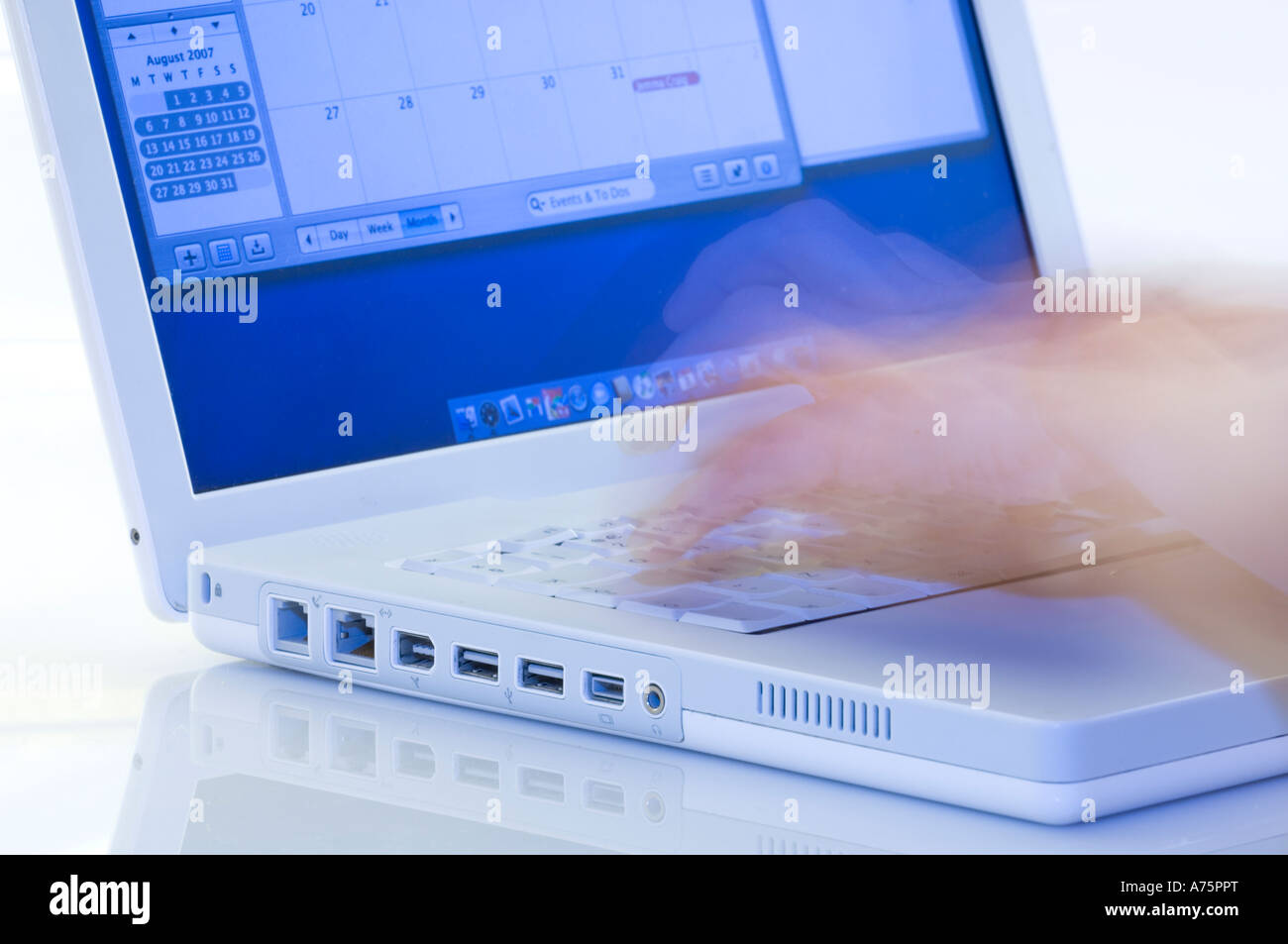 Hands typing at speed on laptop computer keyboard against white ...