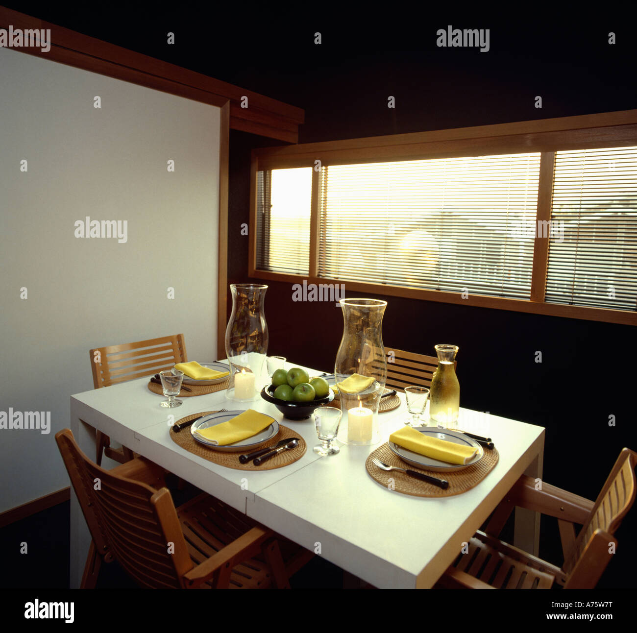 White formica-topped dining table with yellow napkins and amber ...