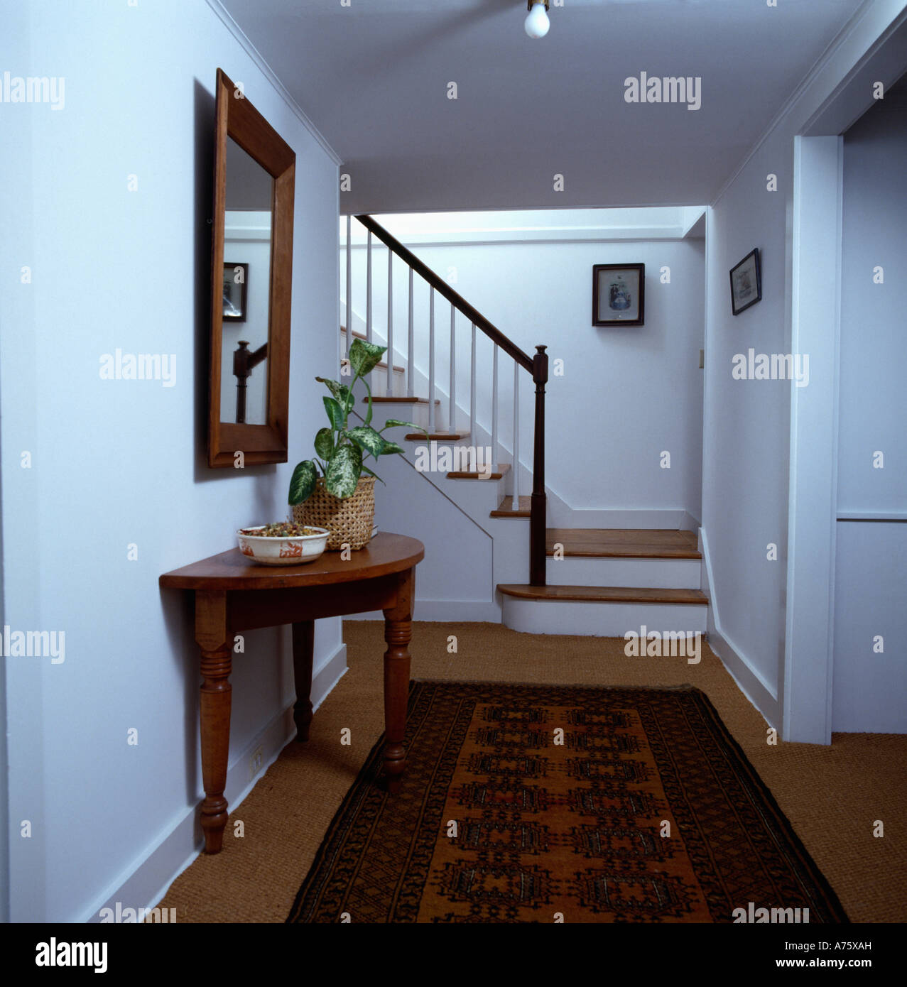 Sisal carpet in white hall with wooden console table Stock Photo - Alamy