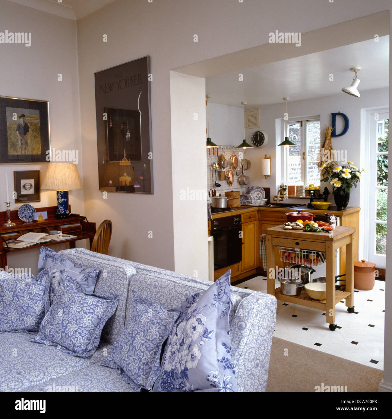 Blue and white floral patterned settee in small apartment with kitchen ...