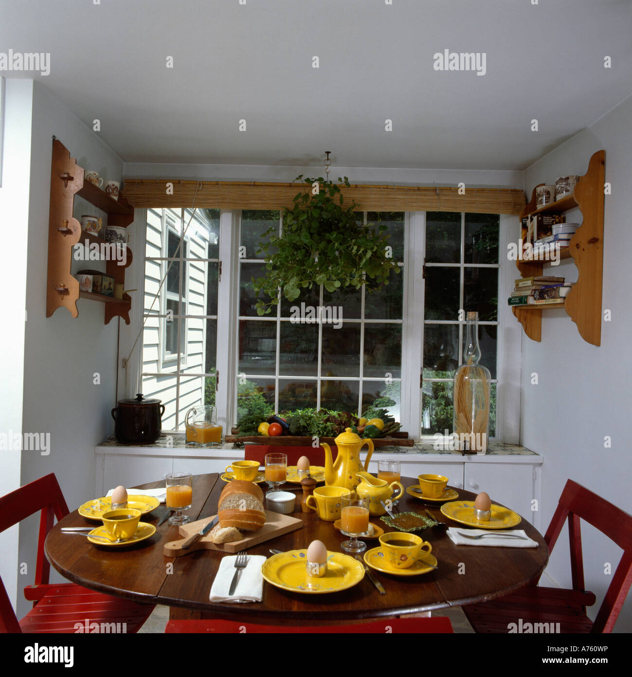 Breakfast table with yellow pottery crockery in small white country ...