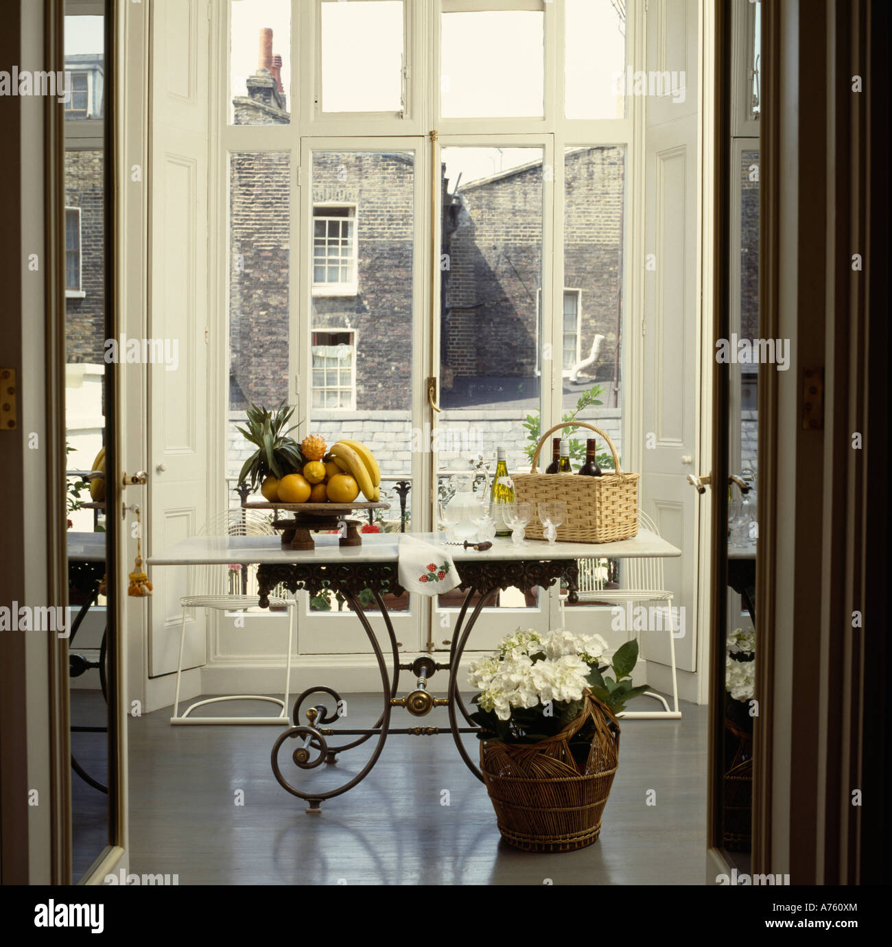 View through open double doors of metal table in front of large window ...