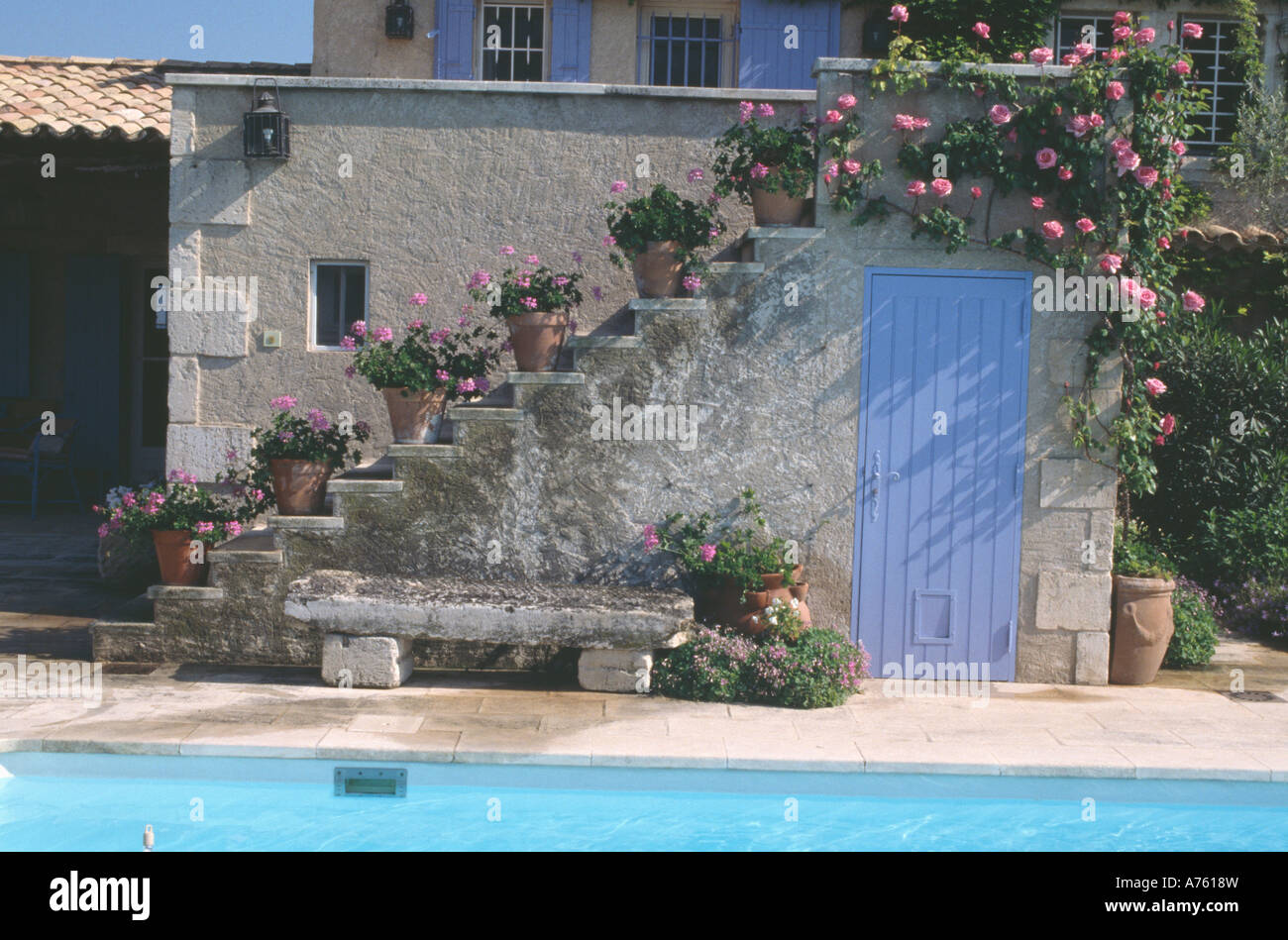 Provencal house with outside steps and blue door beside swimming pool ...