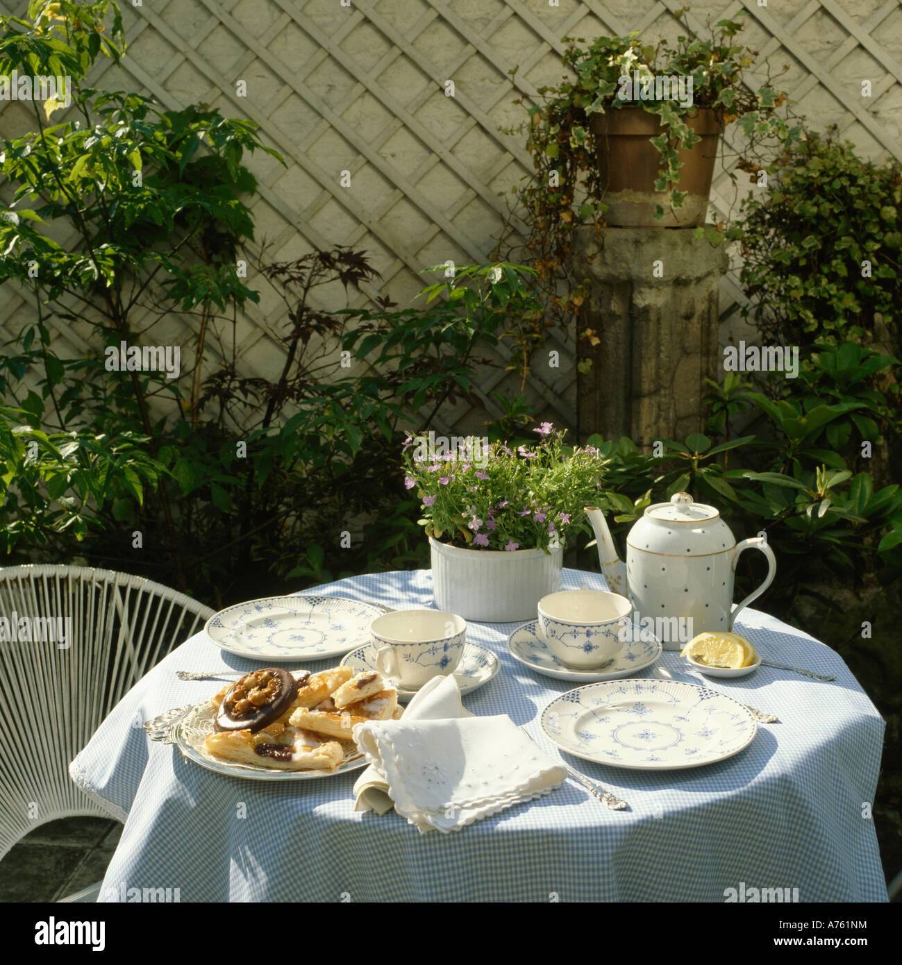 Table set for tea with teapot and cakes on white table cloth in Stock ...