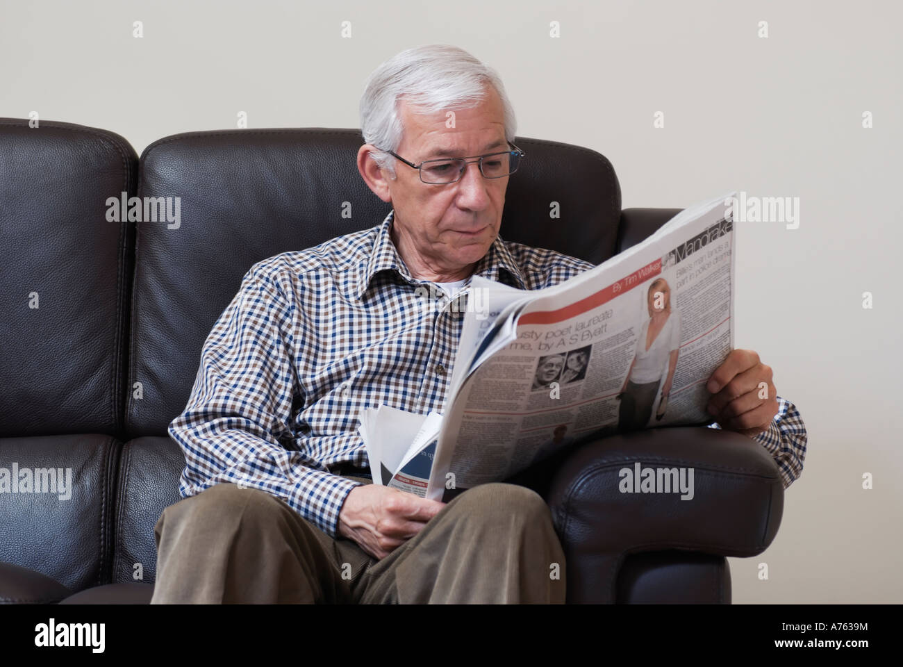An elderly man reading a paper newspaper Stock Photo - Alamy