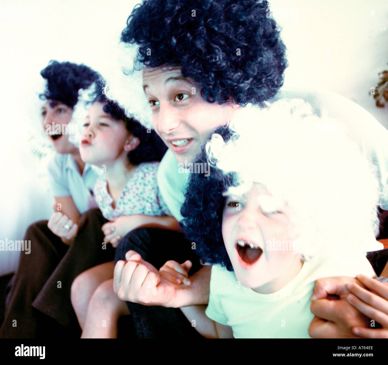 family cheering wearing wigs Stock Photo - Alamy