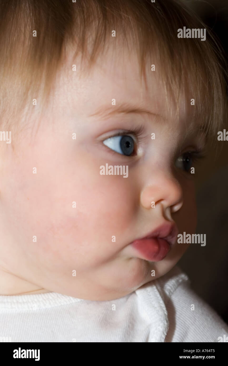 Baby girl closeup looking right in a questioning manner Stock Photo - Alamy