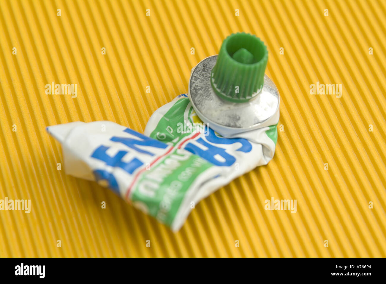 Toothpaste on yellow surface Stock Photo - Alamy