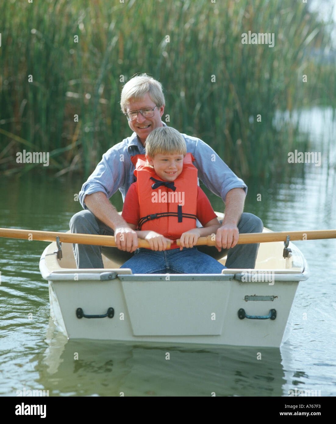 father teaching his son to row a boat Stock Photo - Alamy