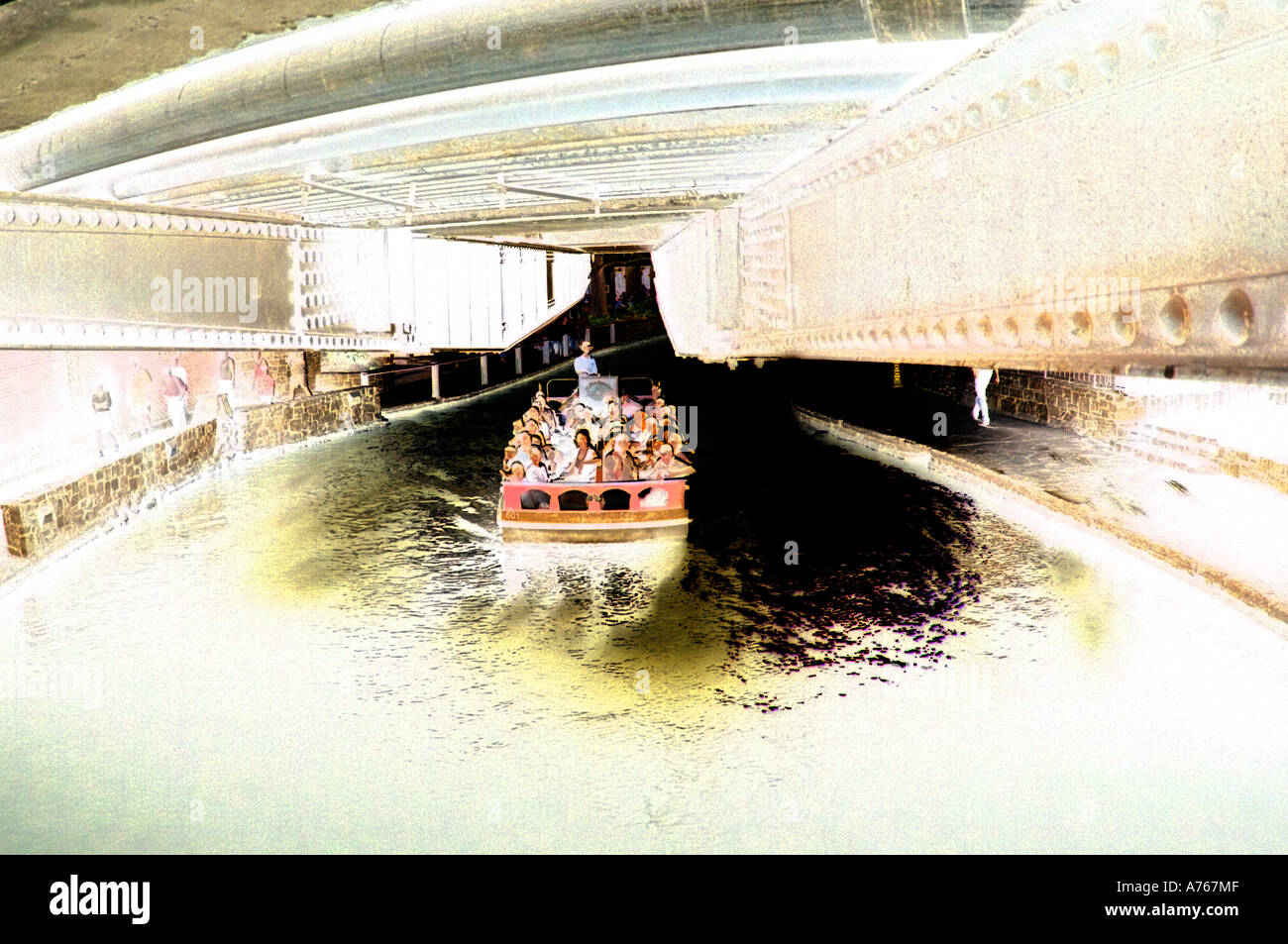 Inverted shot of tour boat as it passes under a bridge near the ...