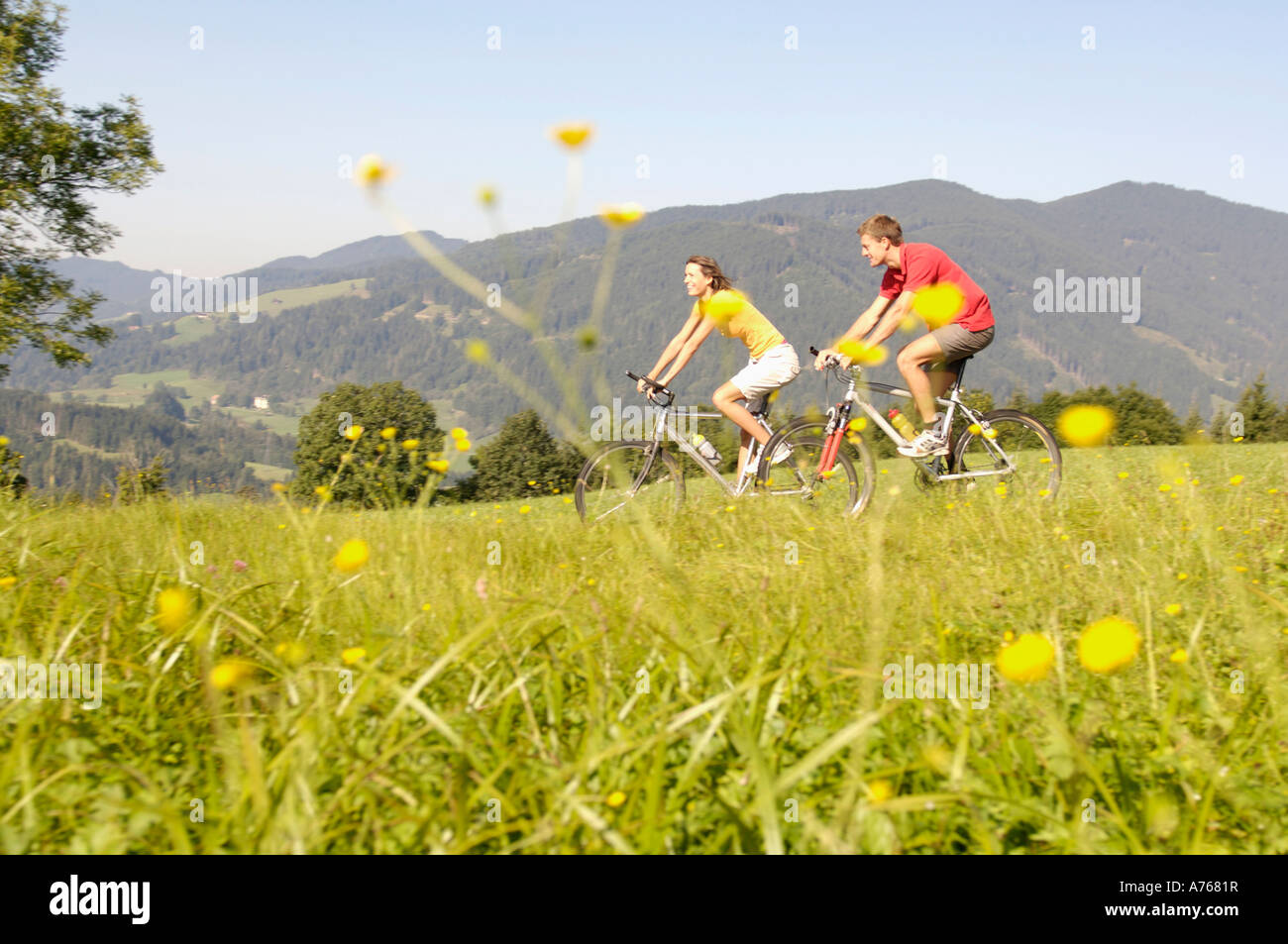 Couple riding bicycle, side view Stock Photo - Alamy