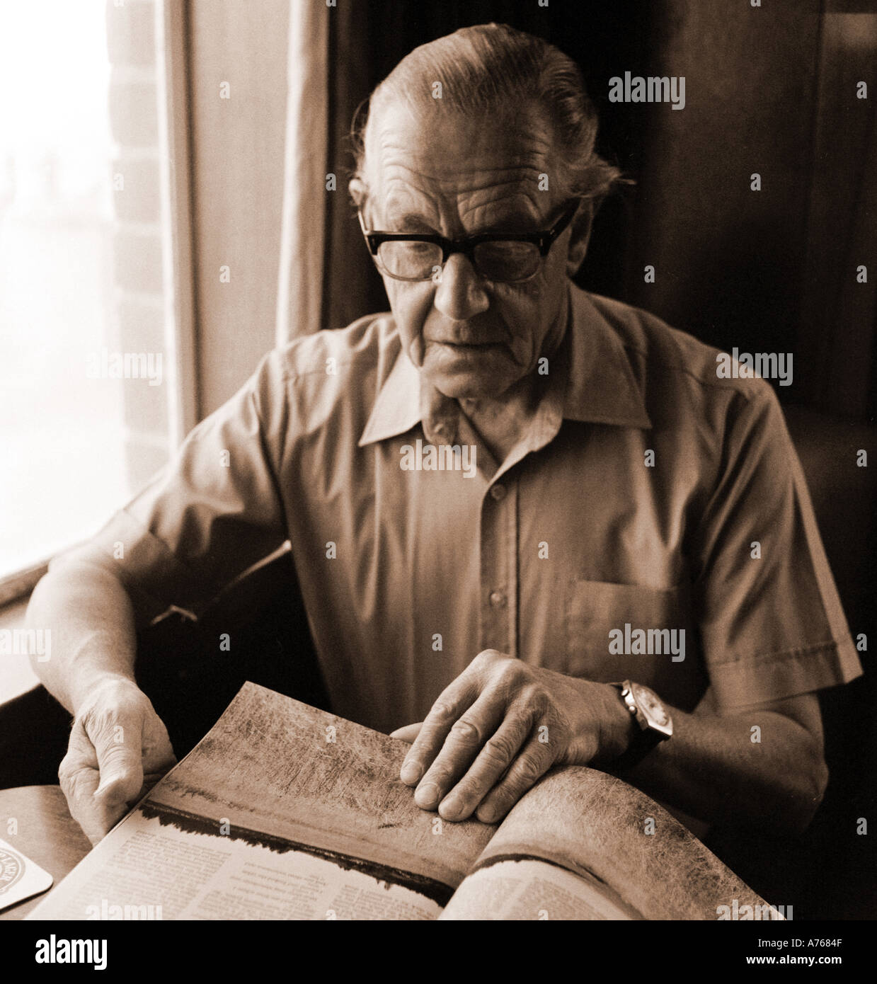 Black and white of Alan Yates reading a book by a window Stock Photo ...