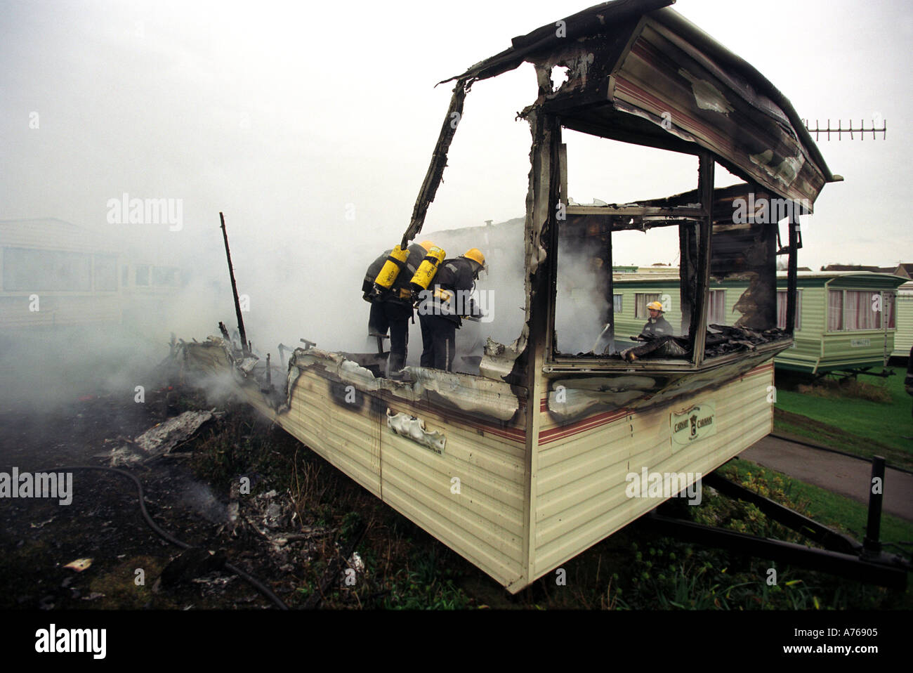 A Firefighter in action at a caravan fire, Britain UK Stock Photo - Alamy