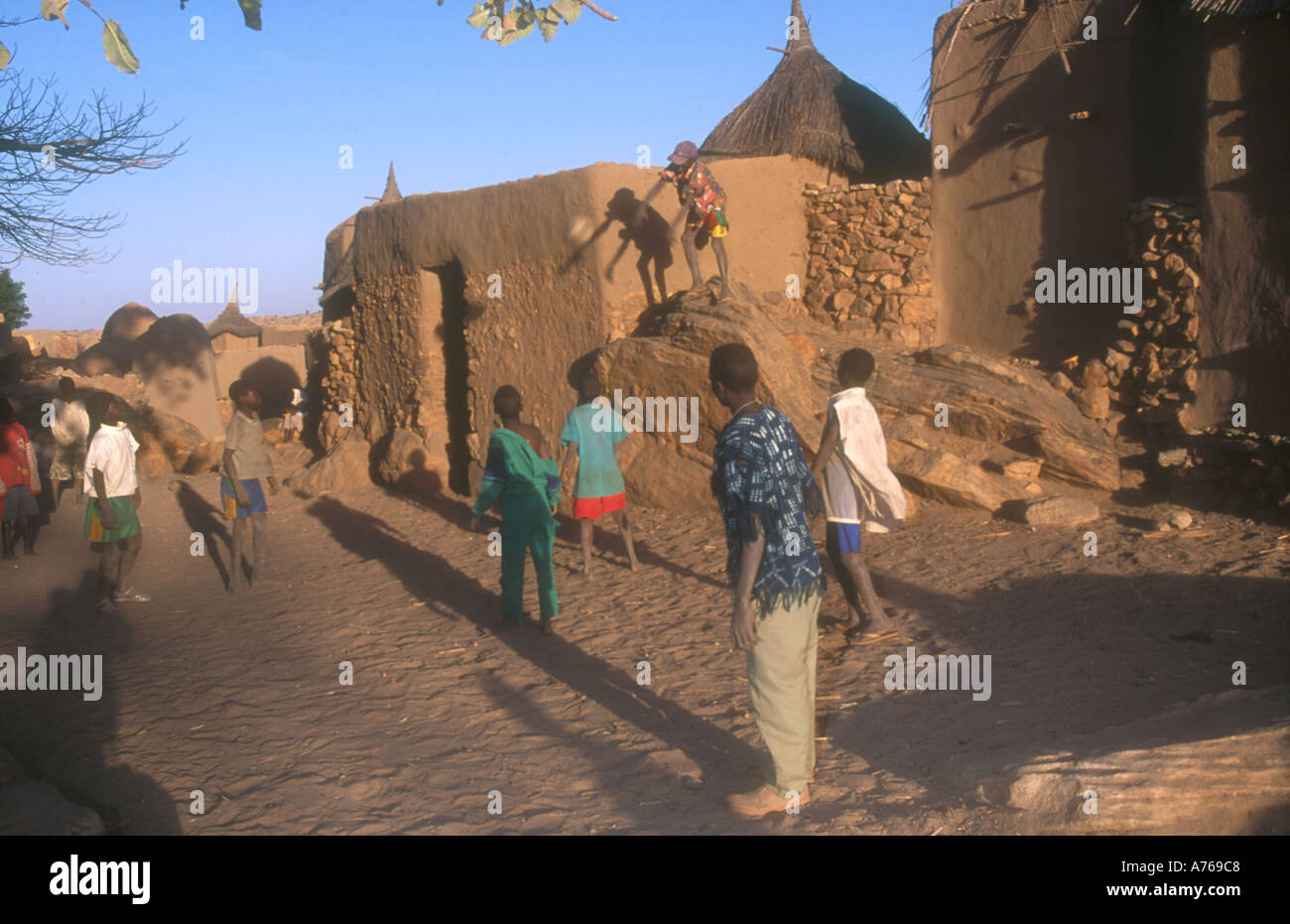 A Dogon boy takes a throw in from a rock during a game of football with ...