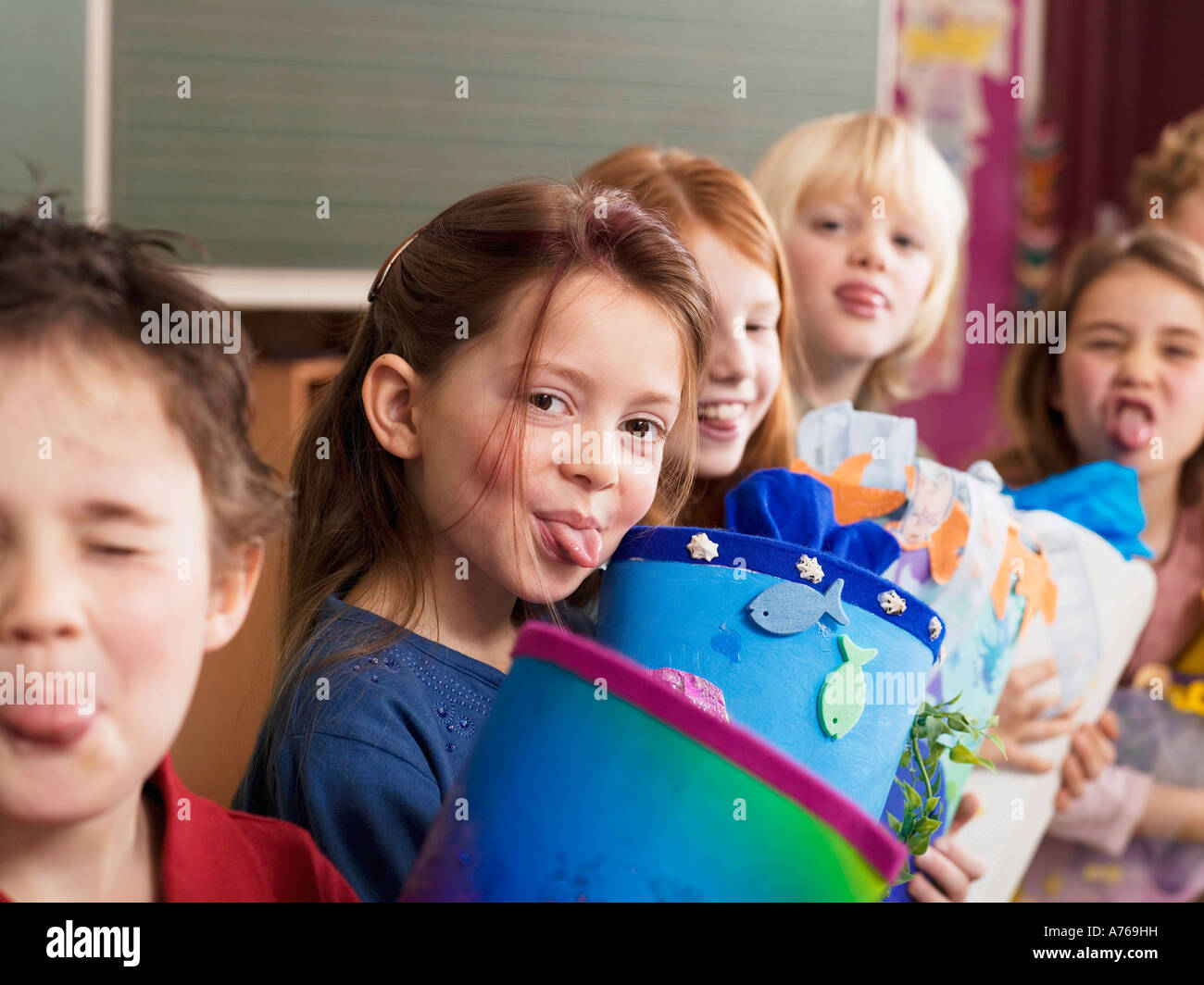 Children (4-7) holding school cone, sticking out tongue Stock Photo - Alamy