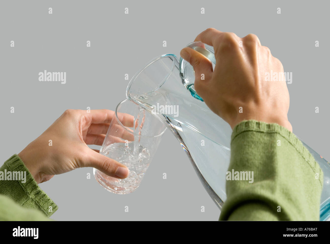 Young woman pouring water from jug into glass, close-up Stock Photo - Alamy