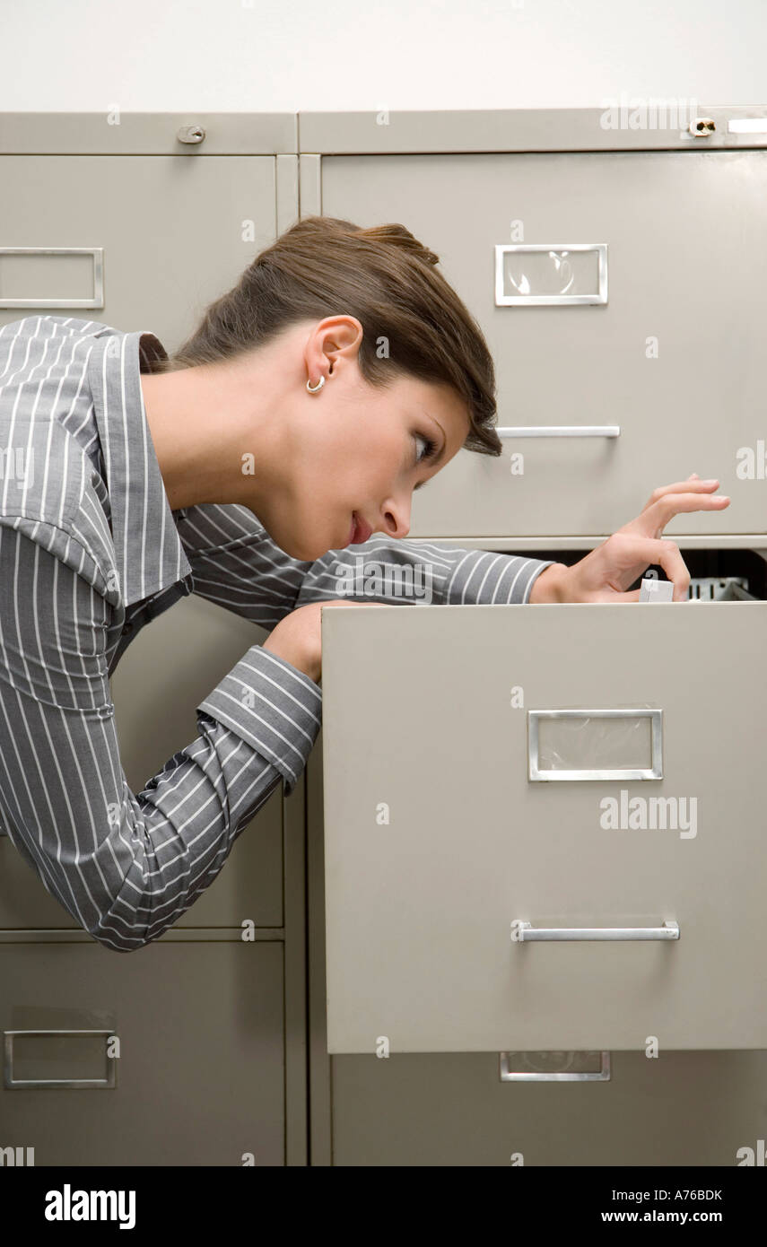 Businesswoman looking through filing cabinet, close-up Stock Photo - Alamy