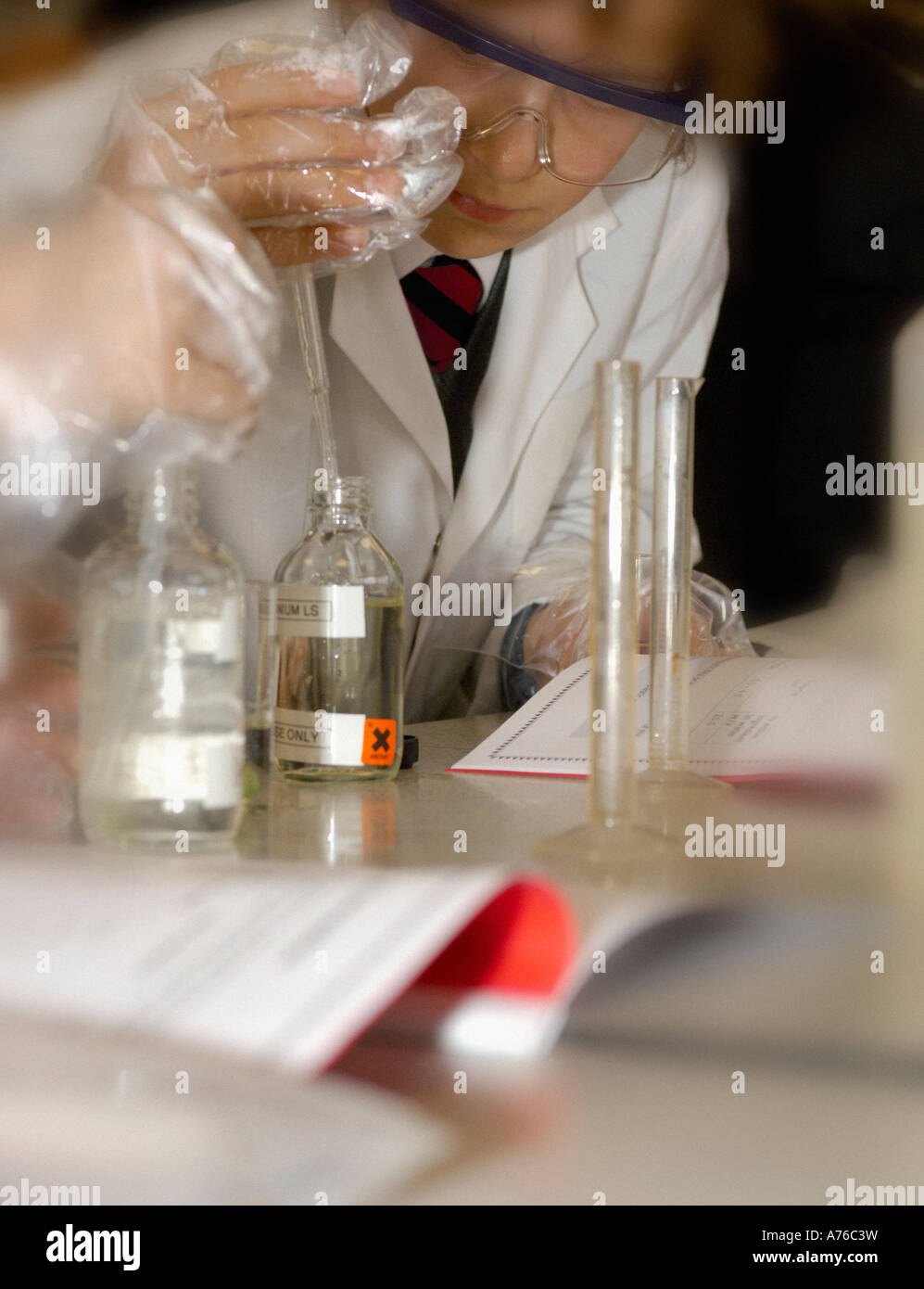 Close-up of an unidentifiable pupil dressed in PPE carrying our ...