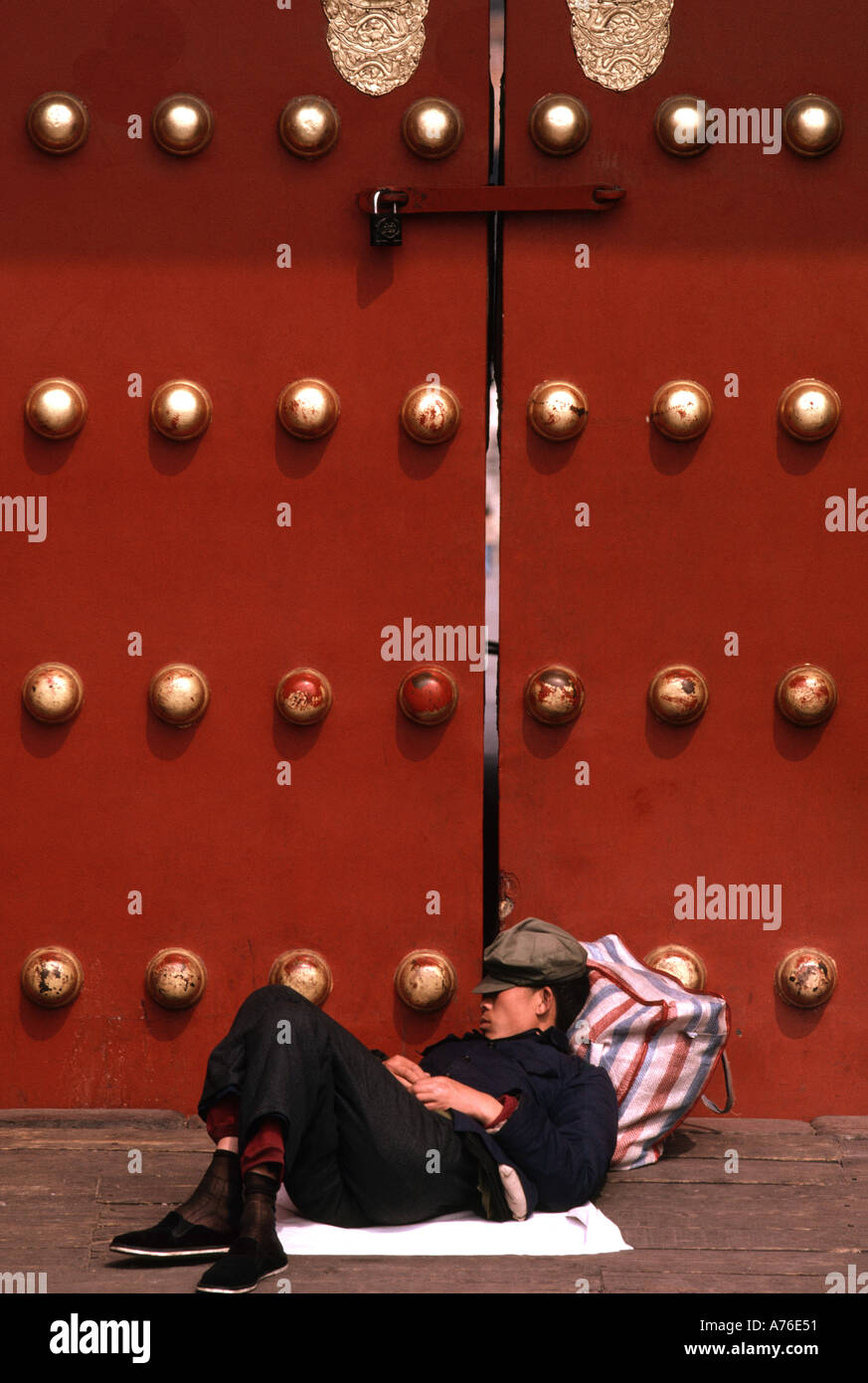 Man taking a sleep in front of a gate in the Forbidden City Beijing ...