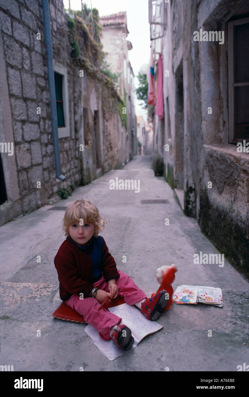 Girl sitting on the ground drawing Stock Photo - Alamy