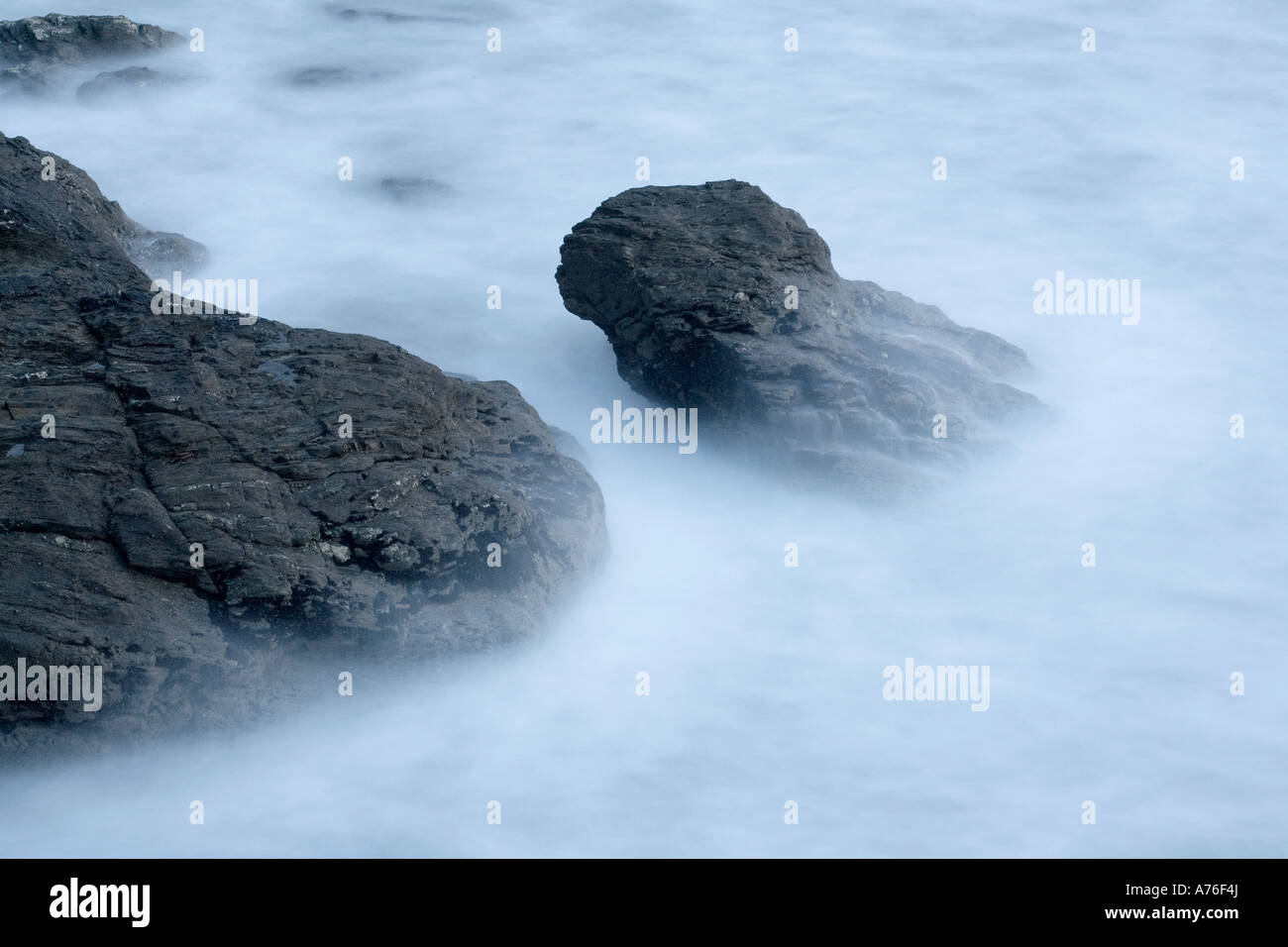 The sea swirls around rocks Stock Photo - Alamy