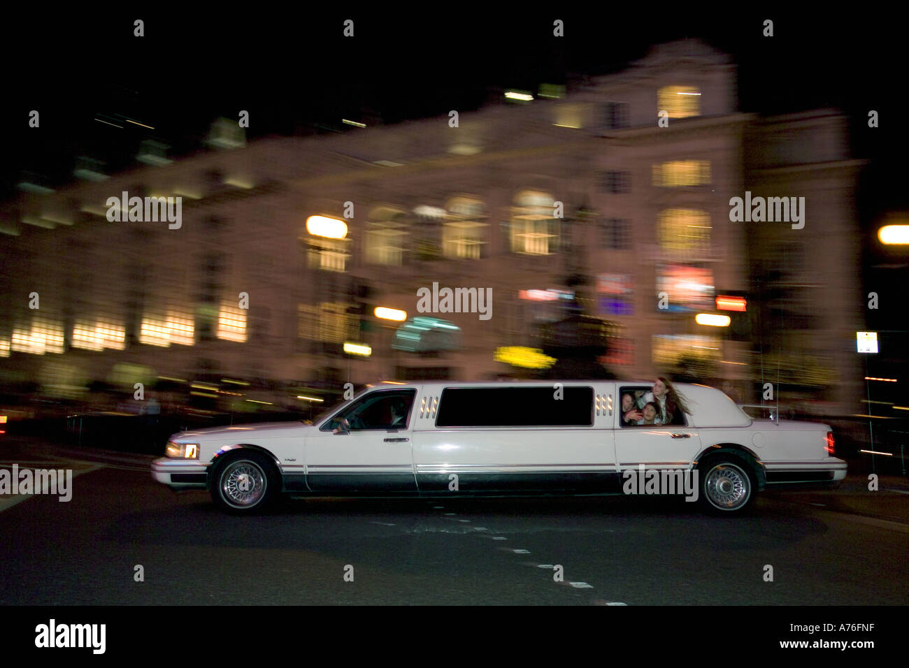 A white stretch limousine around Piccadilly Circus with motion blur ...