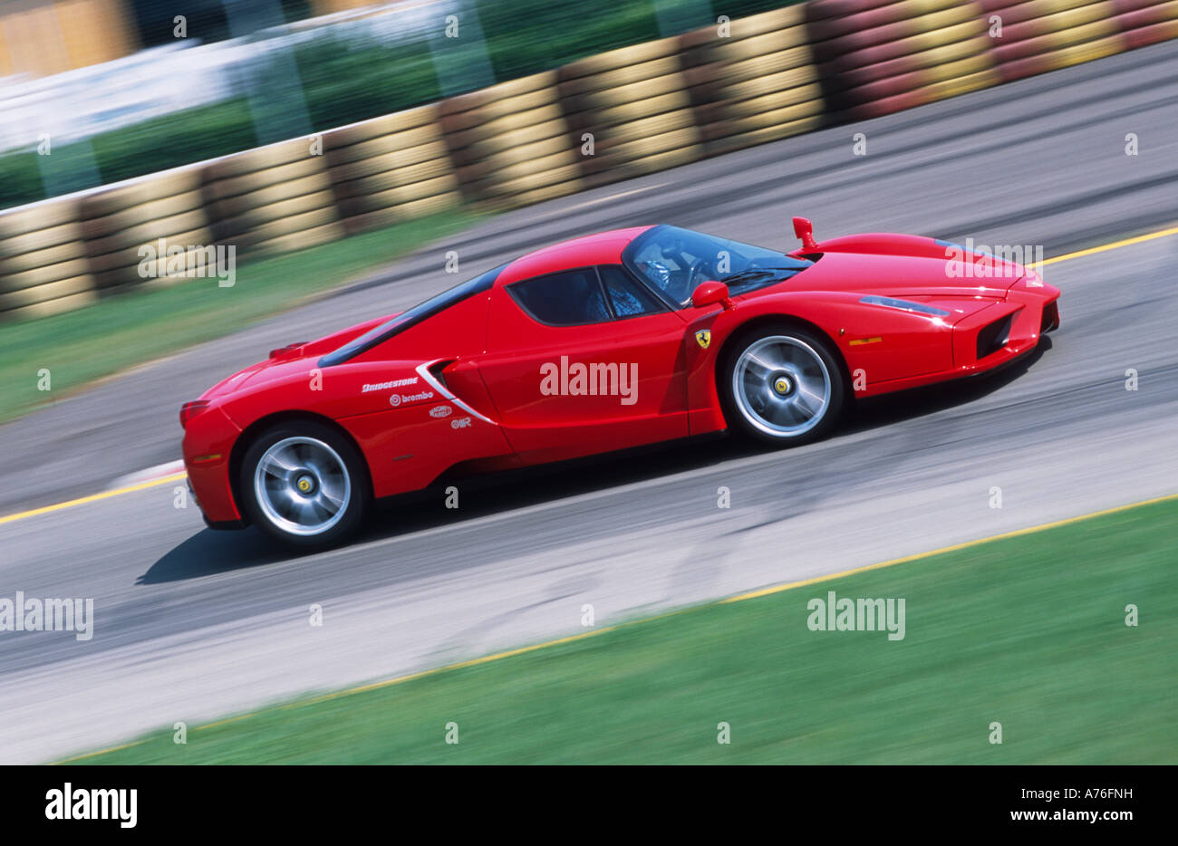 Red Enzo Ferrari driven at speed around Ferrari test track at Fiorano ...