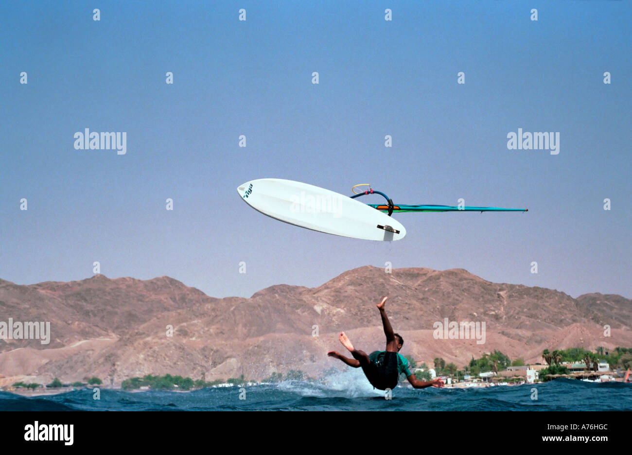 Close up of a wind surfer falling off his board in mid-air whilst ...