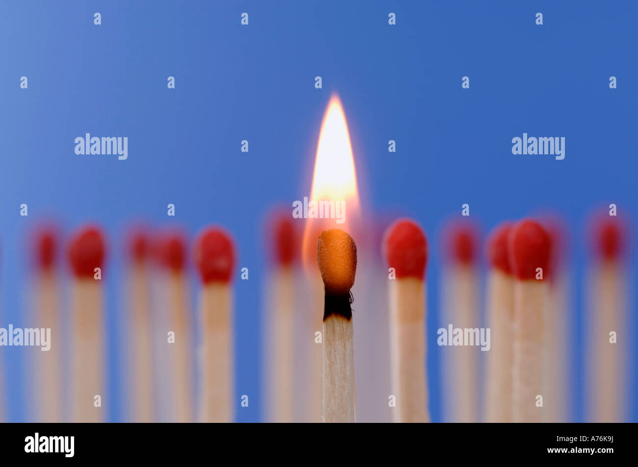 Lit match, red matches in background Stock Photo - Alamy