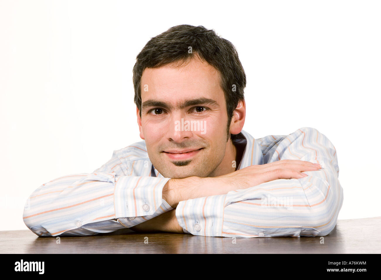 Young man sitting on table Stock Photo - Alamy