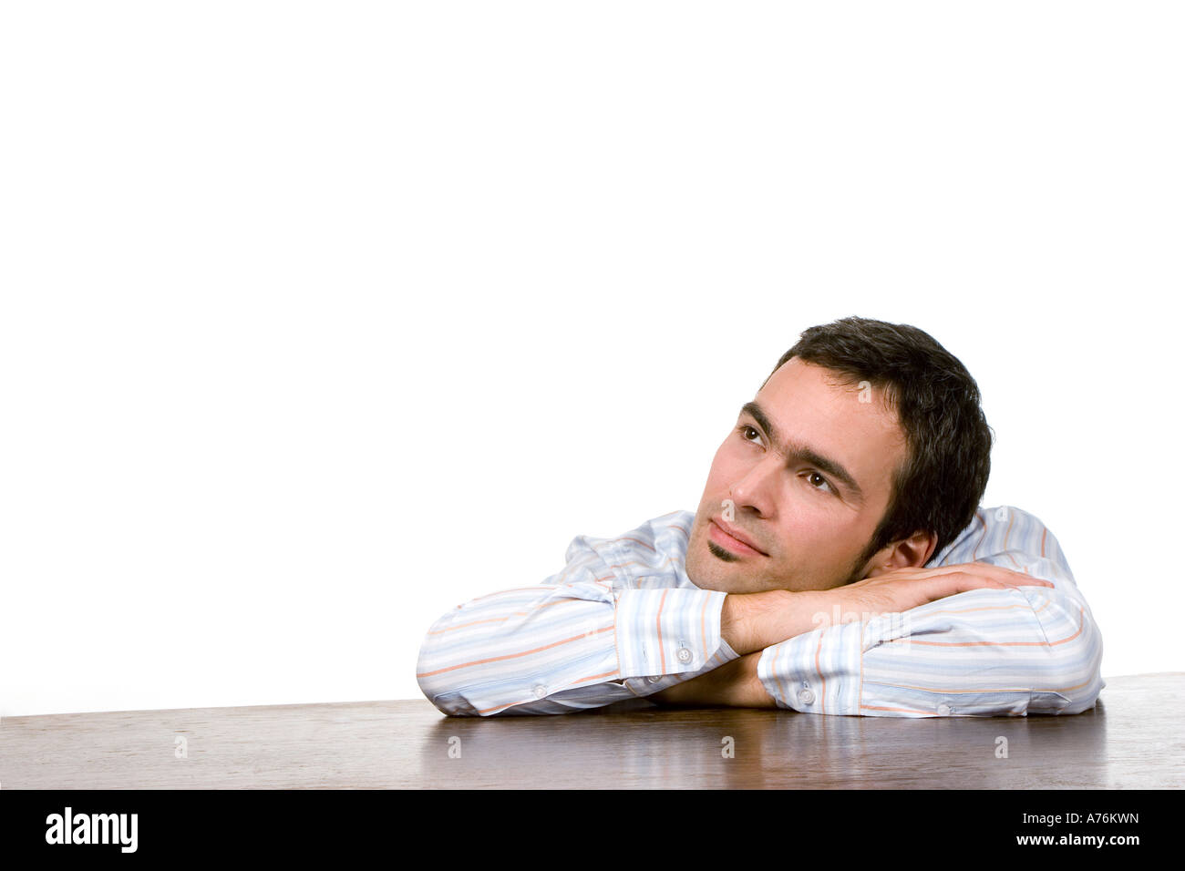Young man leaning on table, looking away, close-up Stock Photo - Alamy