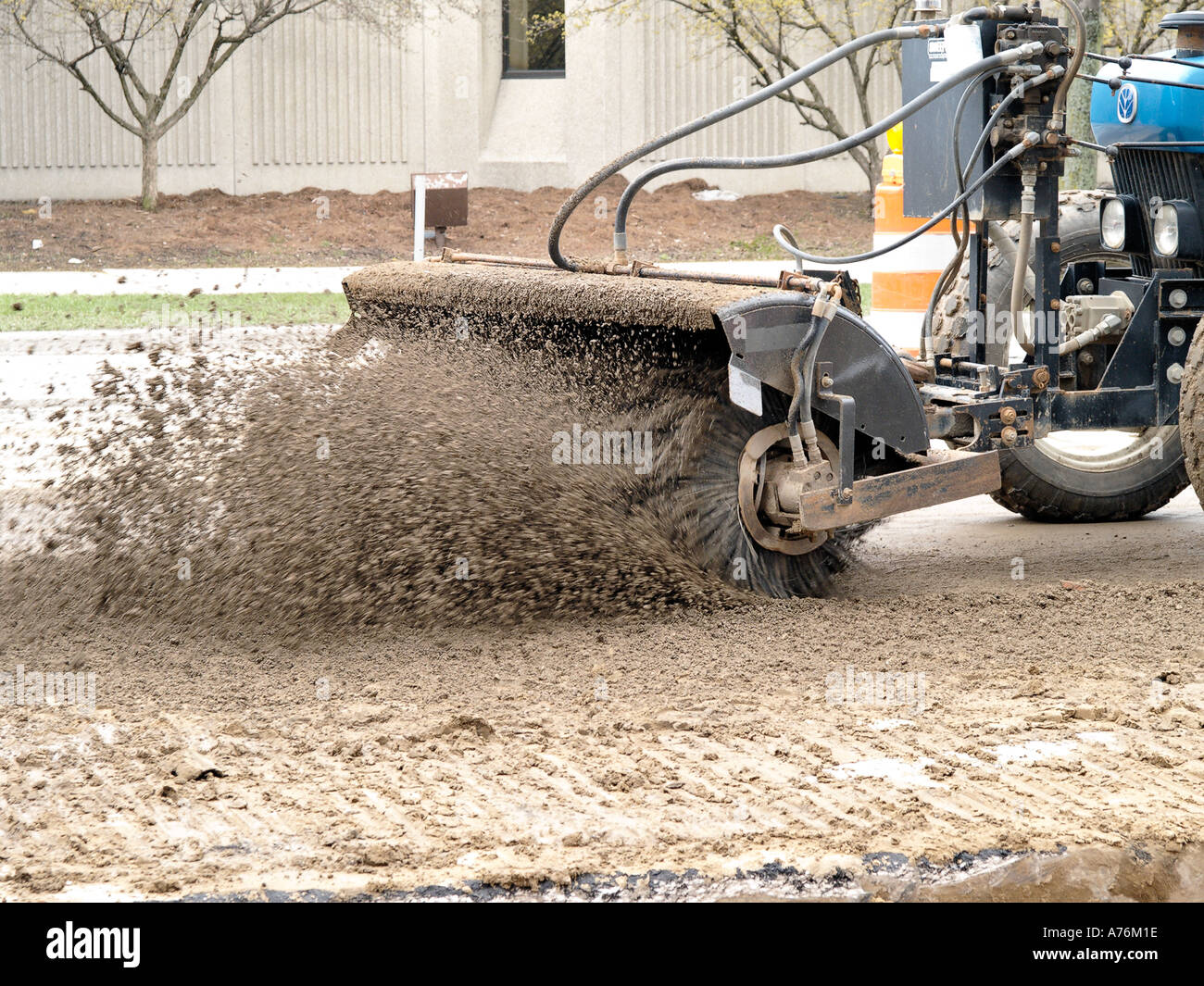 A heavy duty street sweeper clears the mud and debris on the road ...