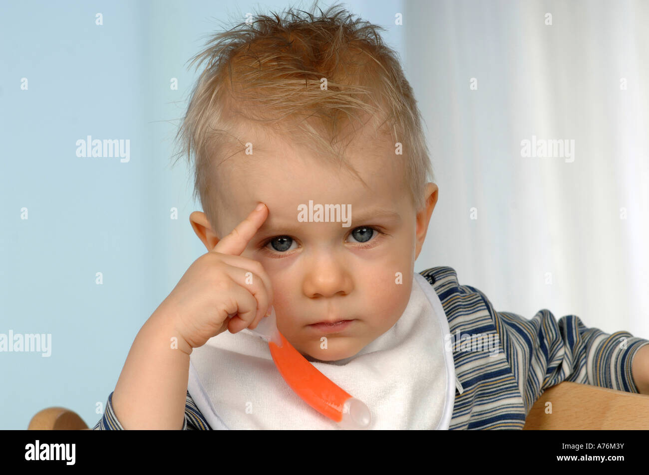 Boy (1-2) holding spoon with finger on forehead, close-up Stock Photo ...