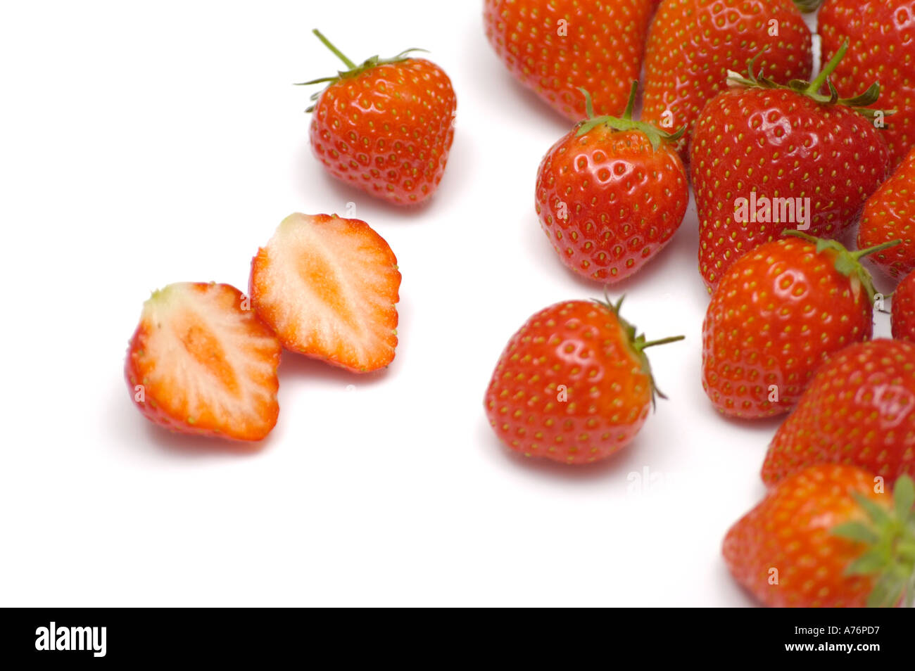 Strawberries fruit with one cut in half on white background Stock Photo ...