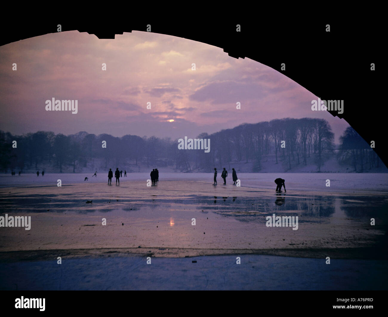 Skating and walking on frozen lake near bridge at Blenheim Palace ...