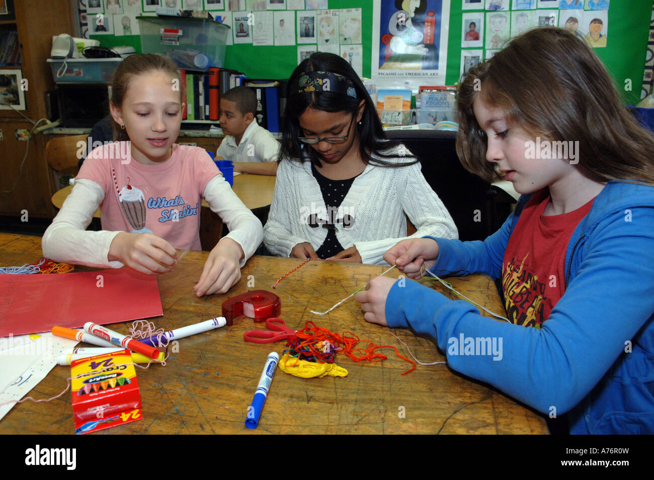 Fifth grade students with their teacher make bracelets to raise money ...