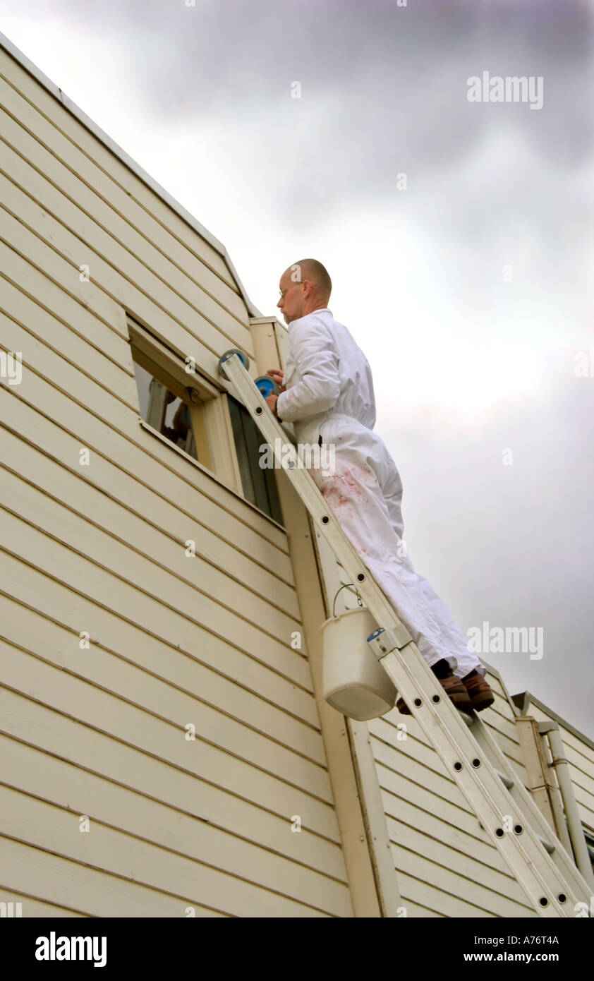Man doing maintenance work standing on aluminum ladder Stock Photo - Alamy