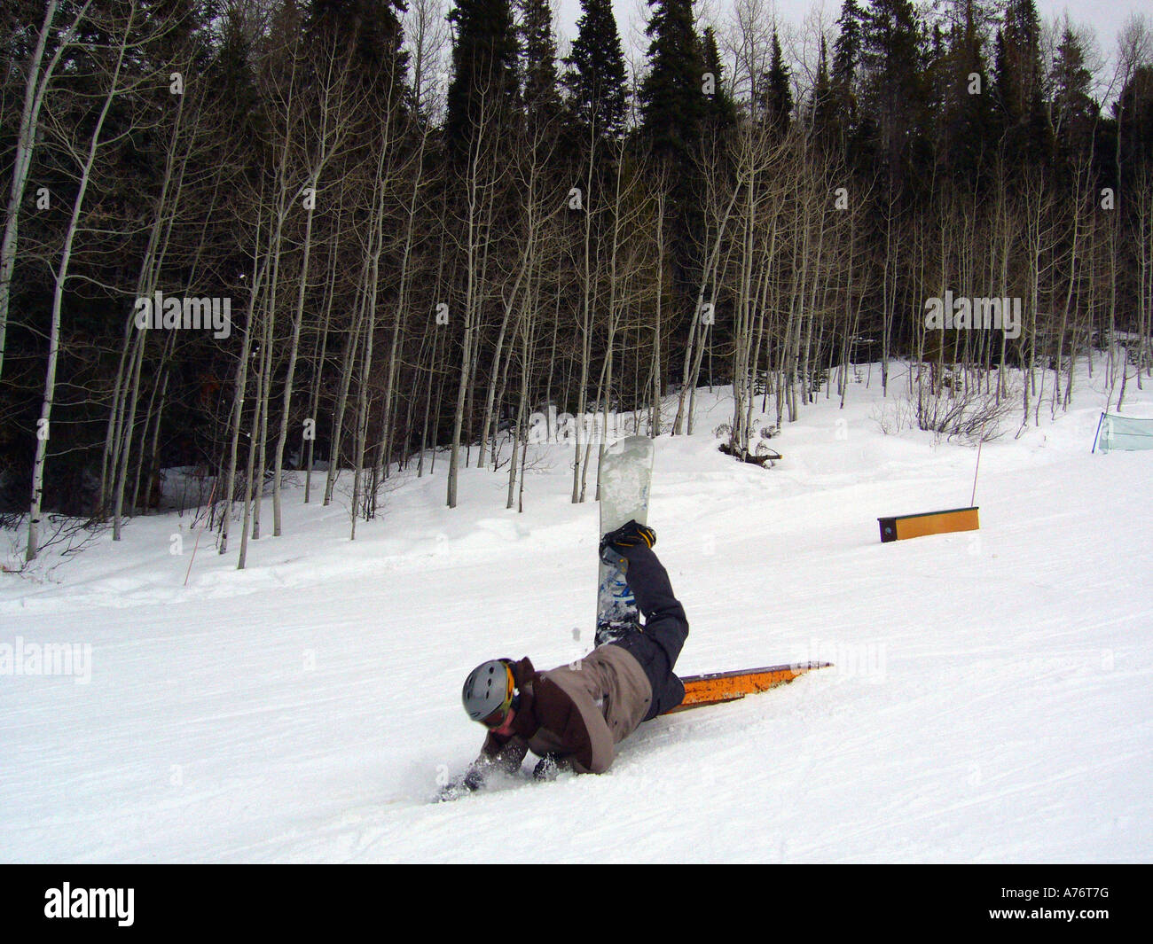 Snowboarder falling on a jump Stock Photo - Alamy
