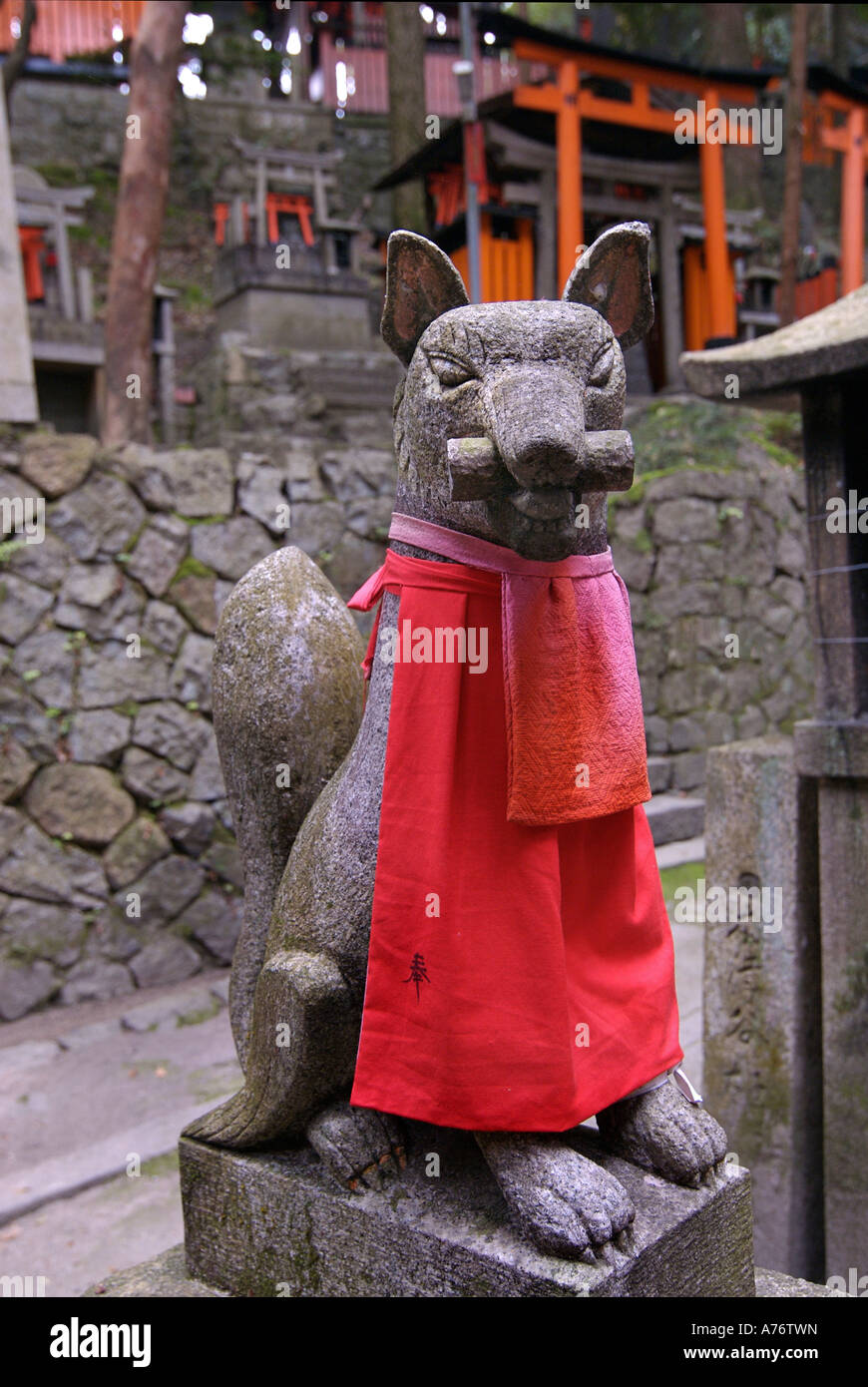 Stone sculpture of a fox with red bib Inari statue Fushimi Inari Taisha ...