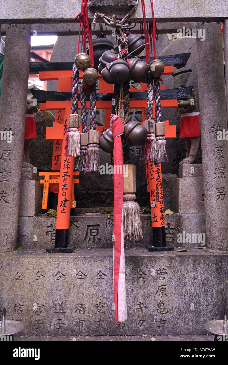 Detail of a sculpted shrine with hanging bells and miniature Torii ...